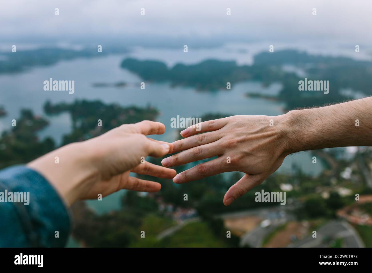 Two hands reaching towards each other with a blurry background of a ...
