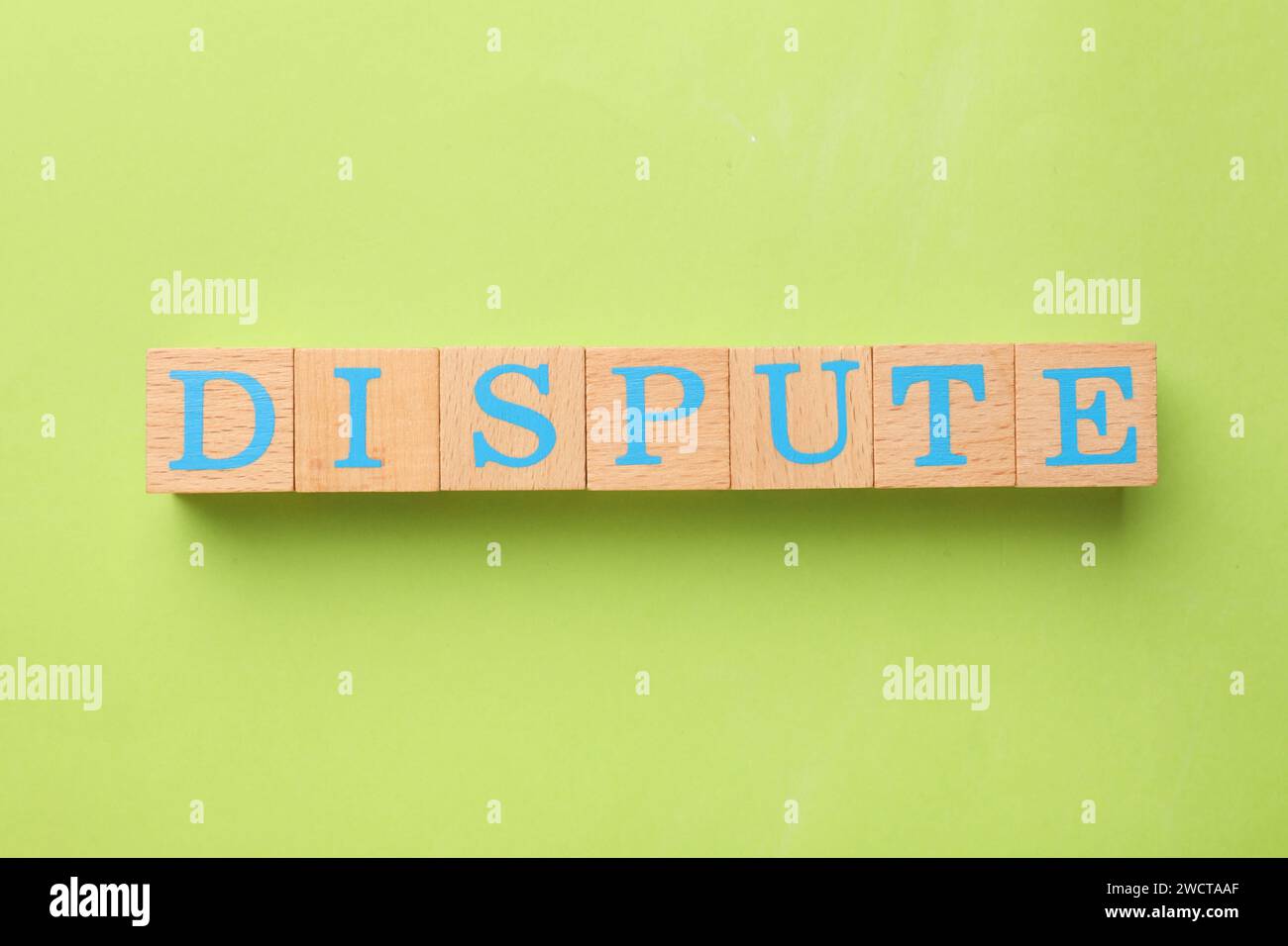 Word Dispute made with wooden cubes on light green background, top view ...
