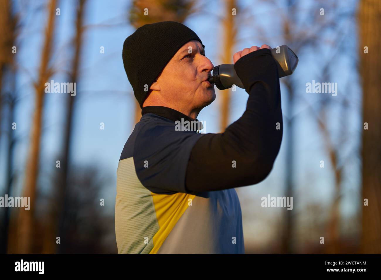 Runner drinking an isotonic drink with electrolytes after running in ...
