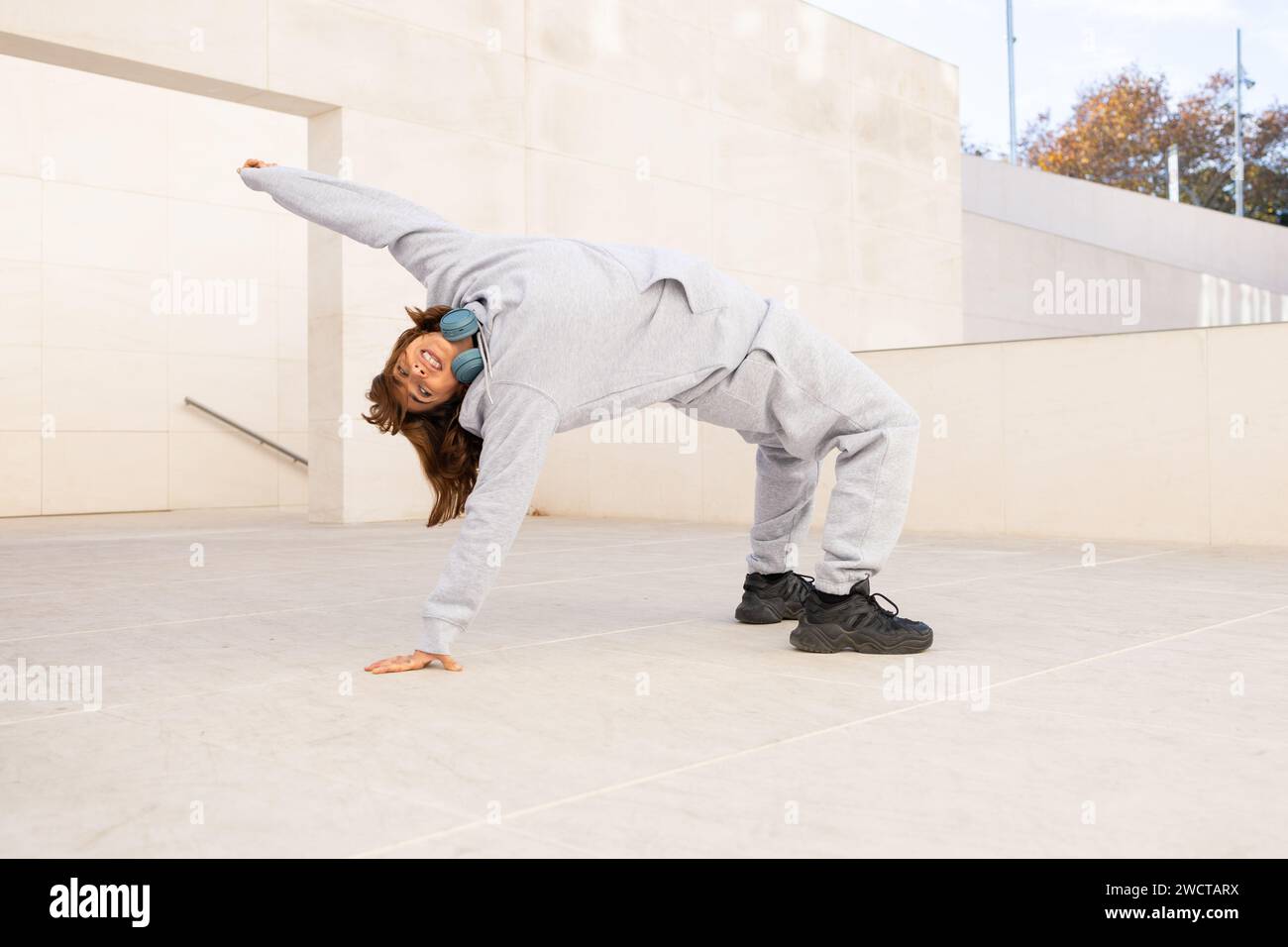 Energetic street dancer with headphones striking a dynamic pose on an ...