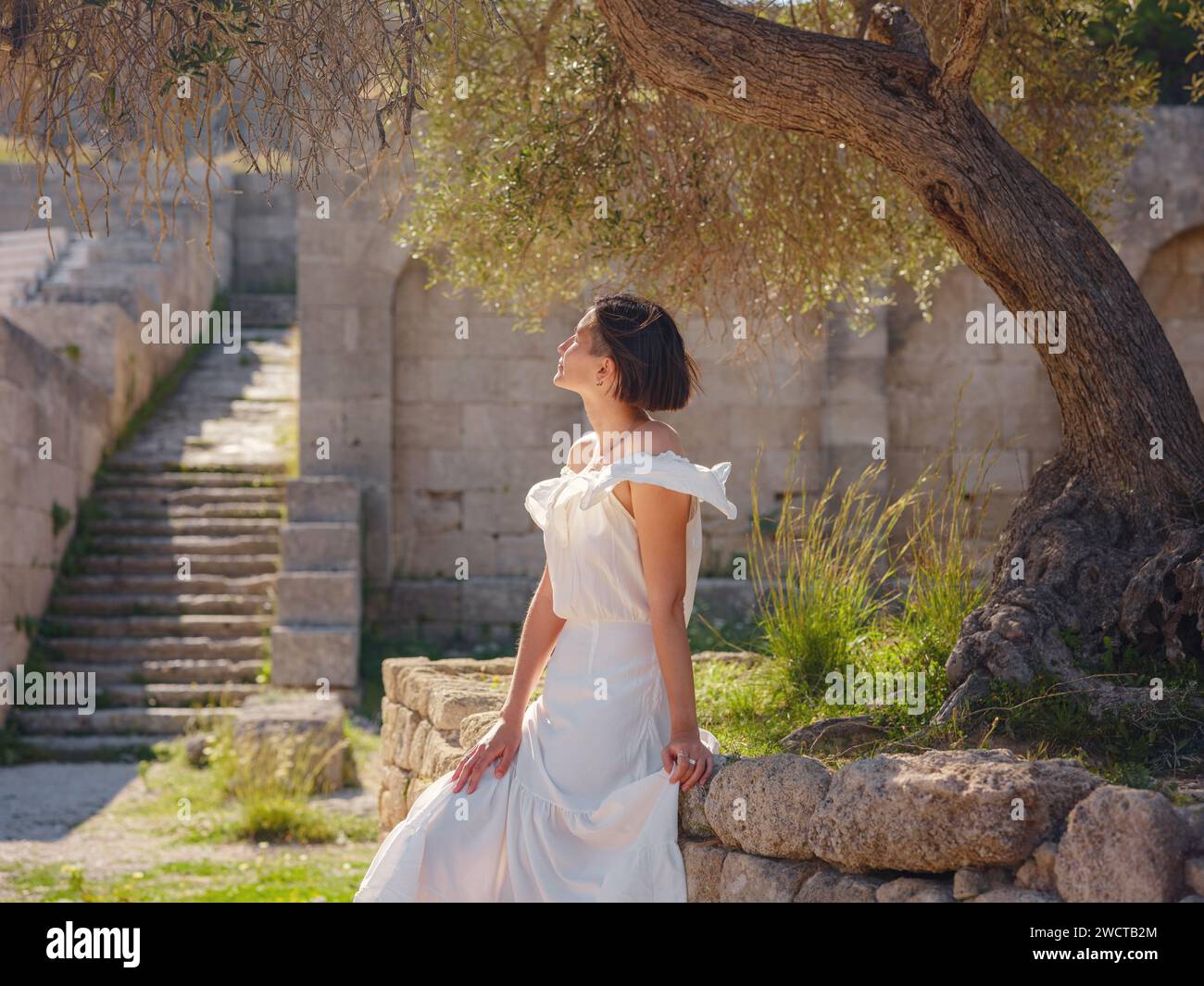 Beautiful Asian young woman in white dress outdoor. Acropolis of Rhodes ...