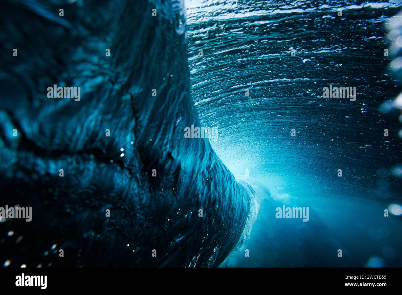 A mesmerizing underwater view of the side of an iceberg with light rays ...