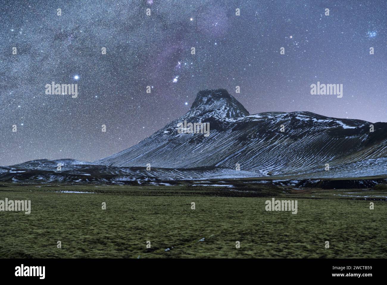 Star-studded night sky with the Milky Way over a snow-dusted mountain ...