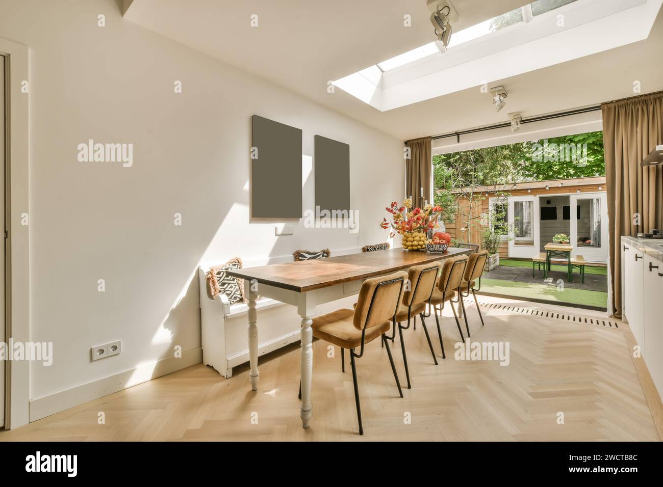 Long wooden dining table and chairs arranged by large window in dining ...