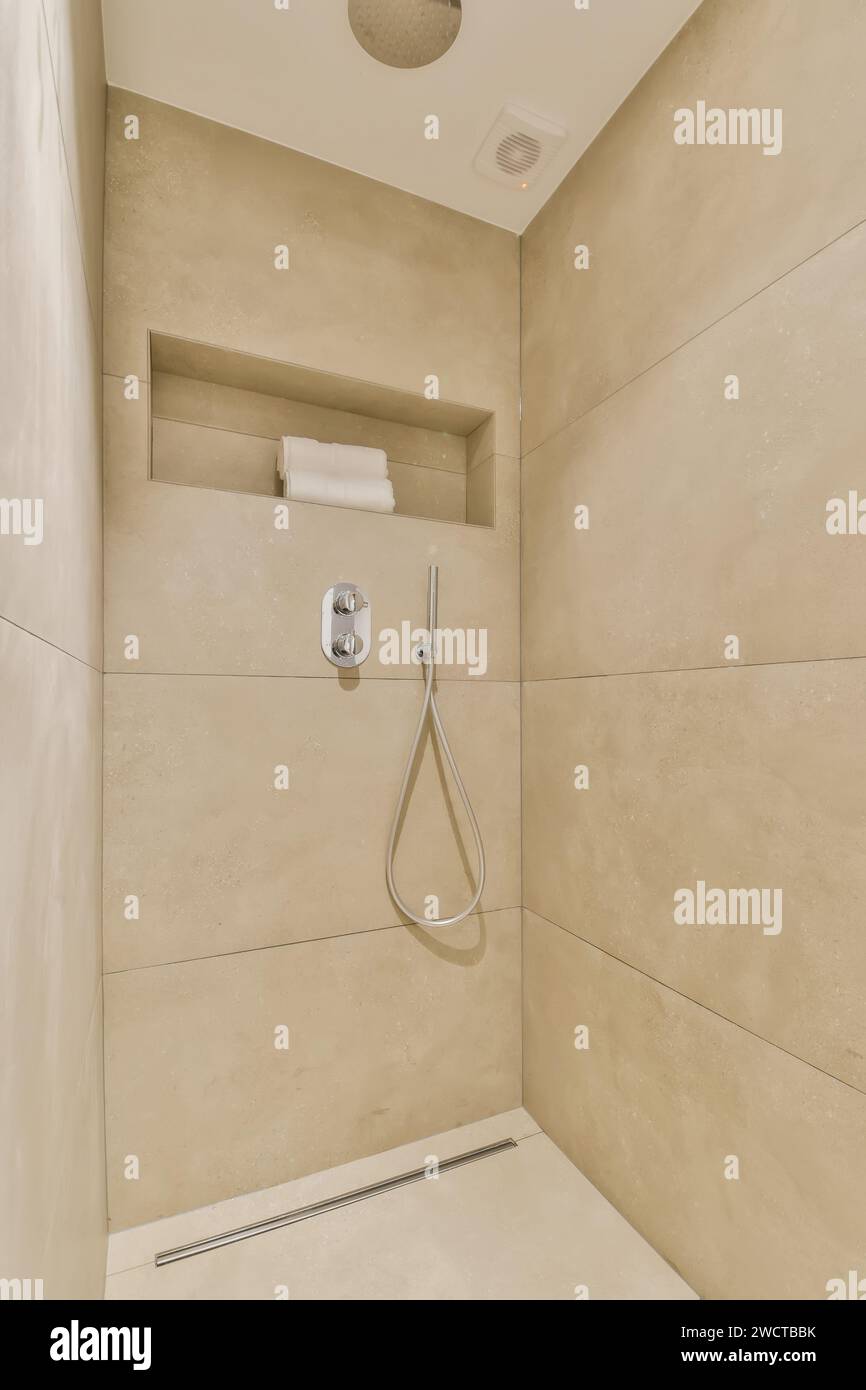 An interior view of a contemporary shower with a simplistic beige color ...