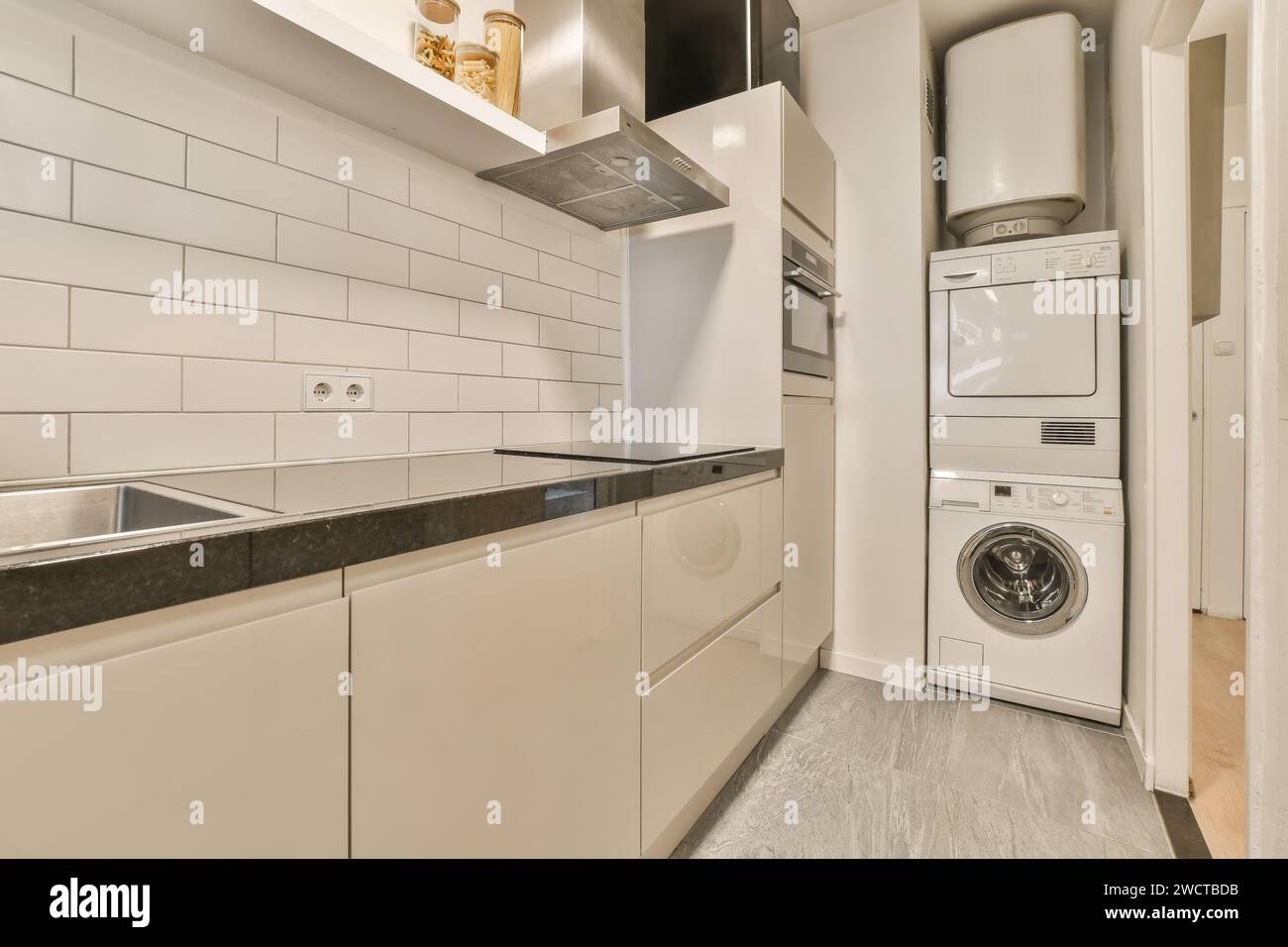 A sleek, modern kitchen interior featuring white cabinetry, integrated ...