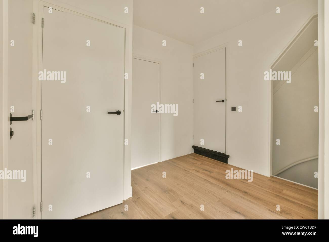 A minimalist interior space featuring sleek white doors and a smooth ...