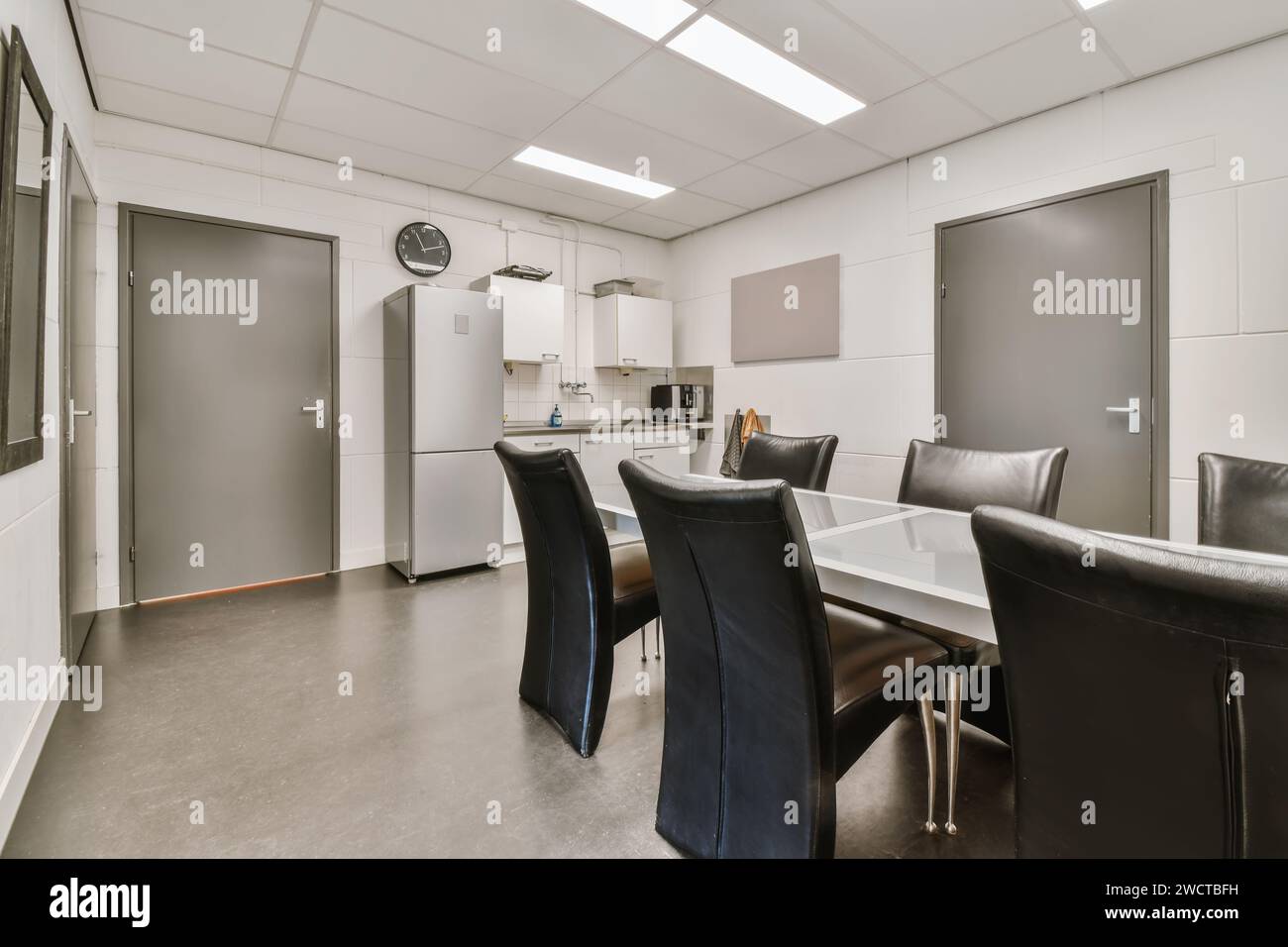 A contemporary office break room featuring a sleek kitchenette, dining ...