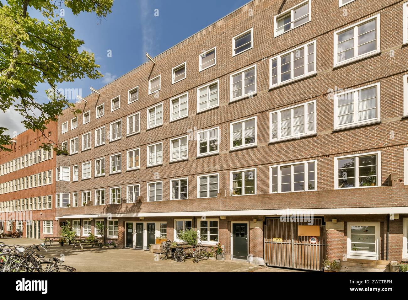 A traditional brick apartment building with rows of large windows, set ...