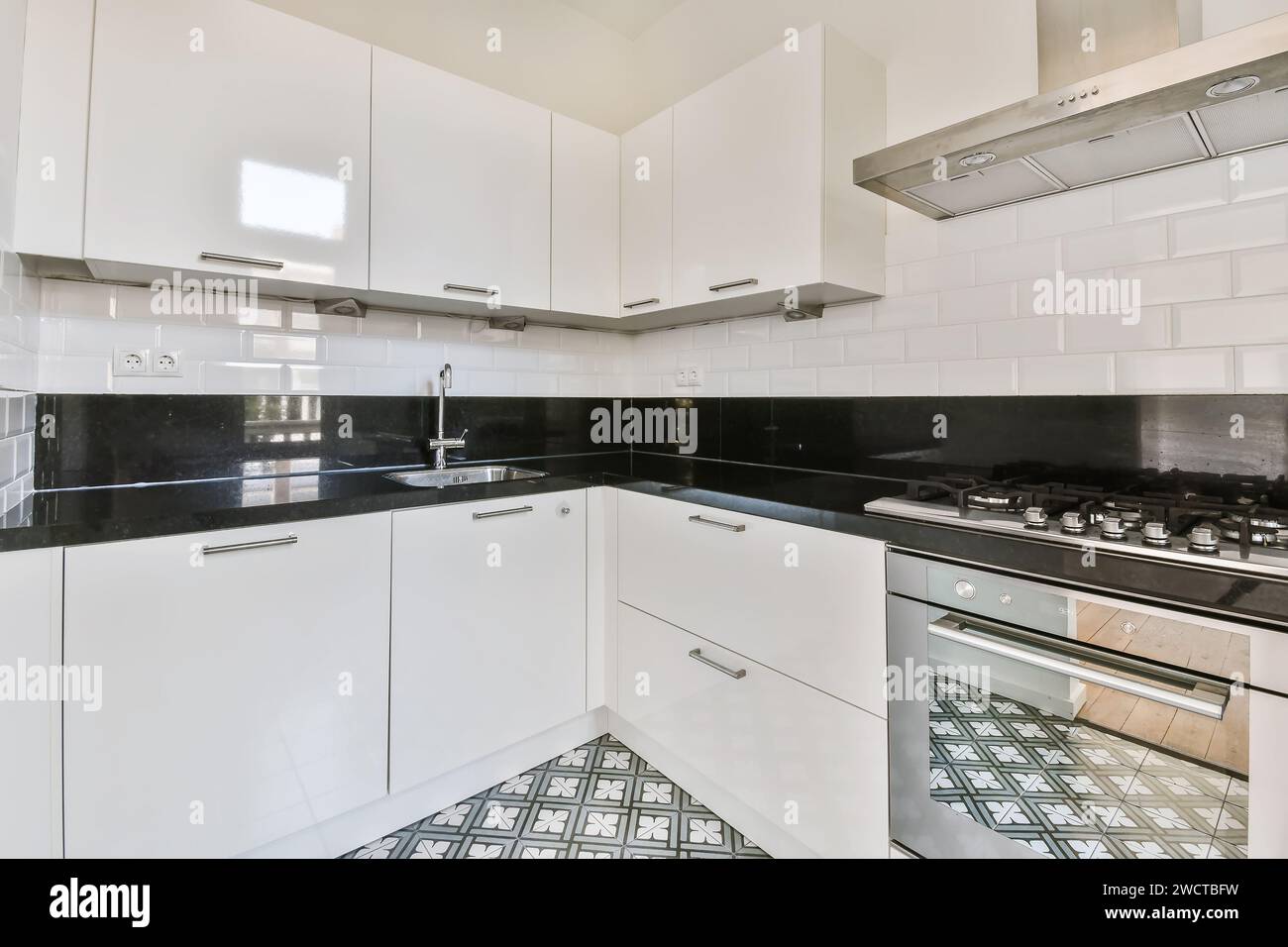 A sleek modern kitchen featuring glossy white cabinets, black granite ...