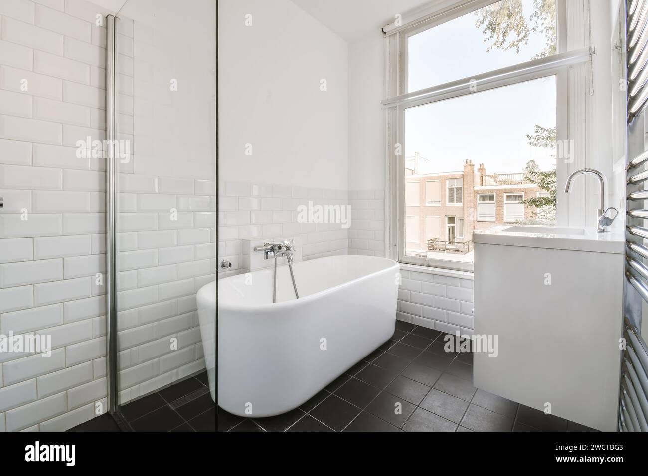 A clean, modern bathroom featuring white subway tiles, a standalone ...