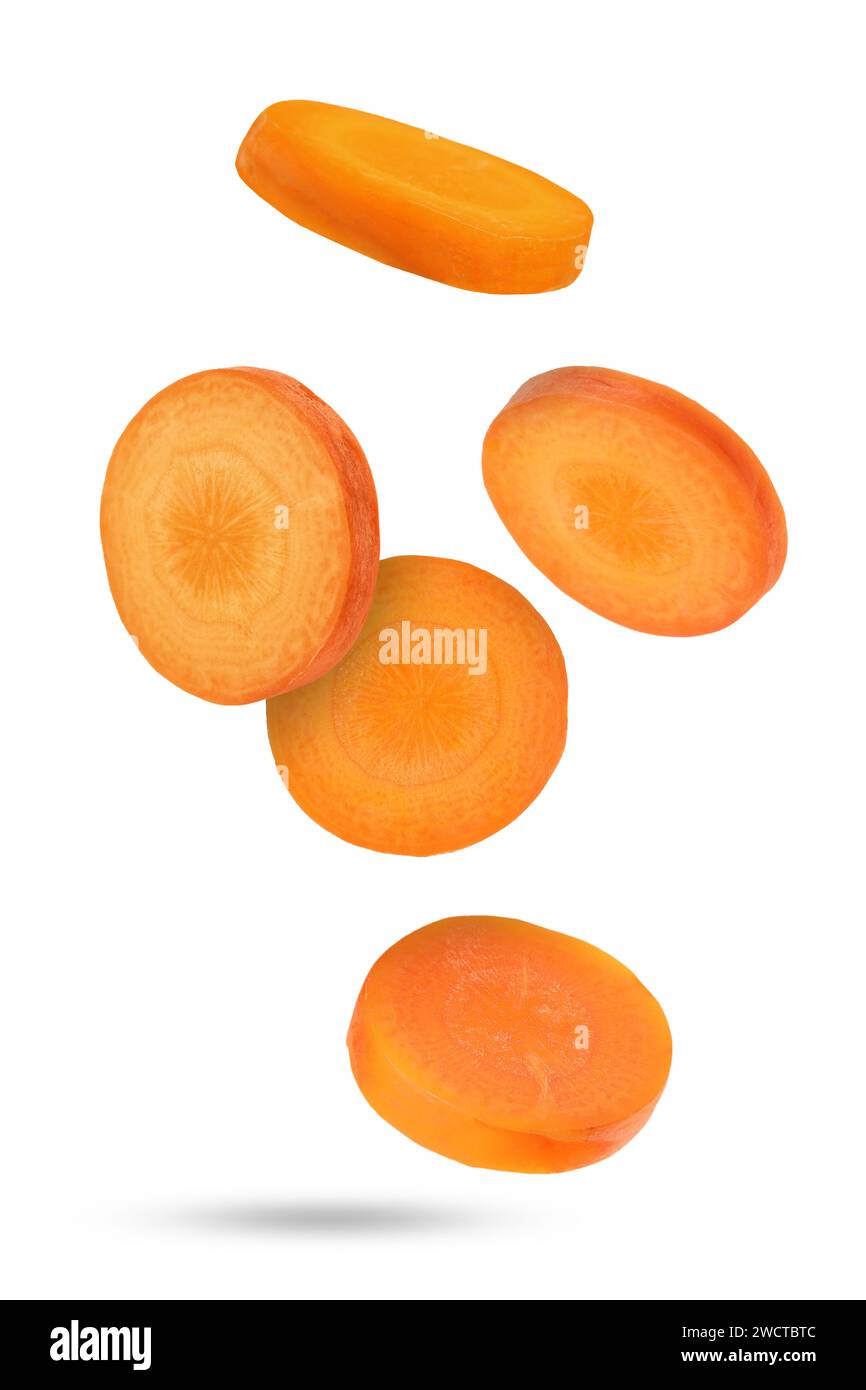 Fresh carrot slices falling on white background Stock Photo - Alamy