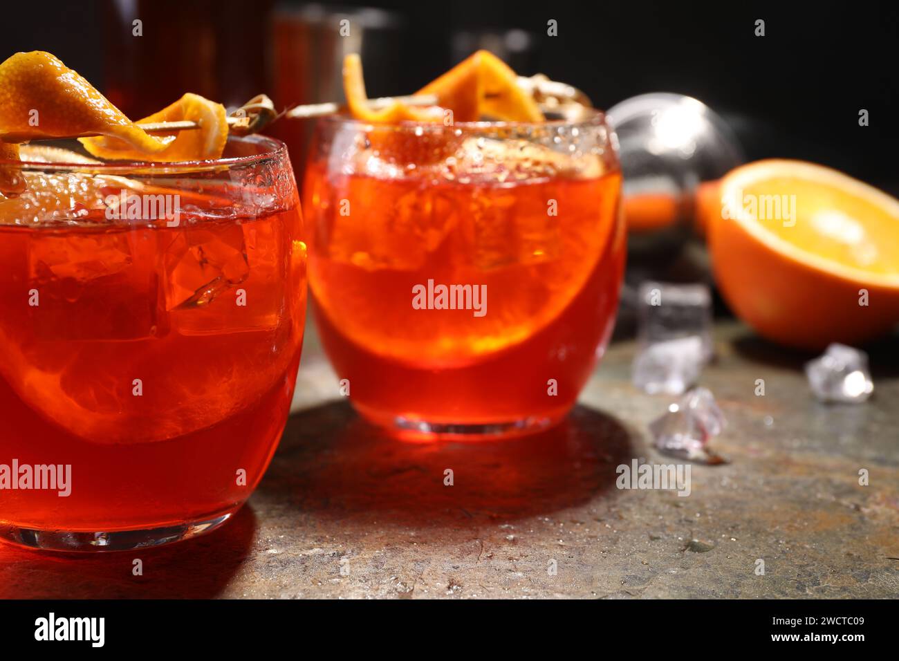 Aperol spritz cocktail, ice cubes and orange slices in glasses on grey ...