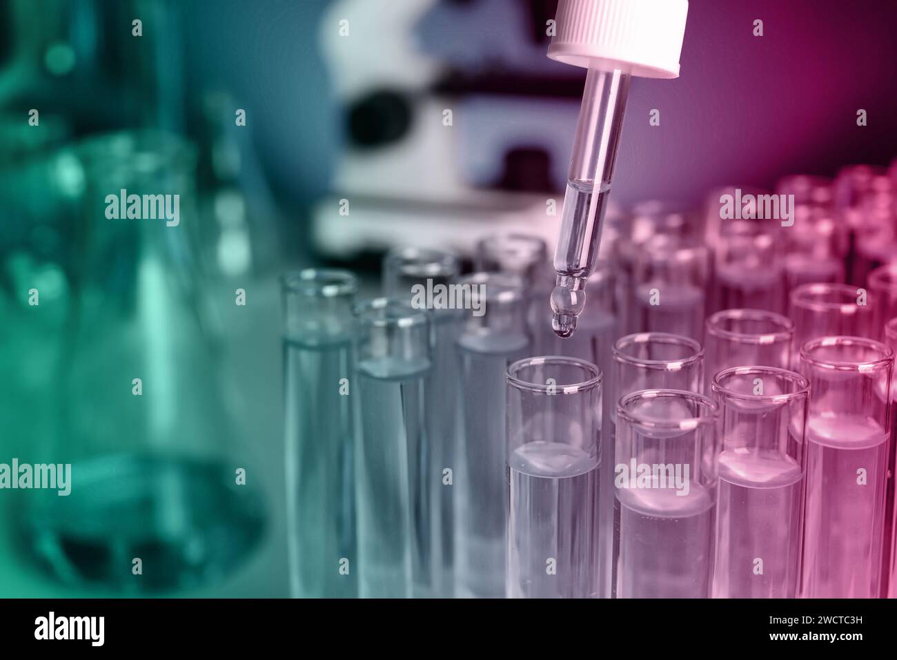 Dripping reagent into test tube with sample at laboratory, closeup ...