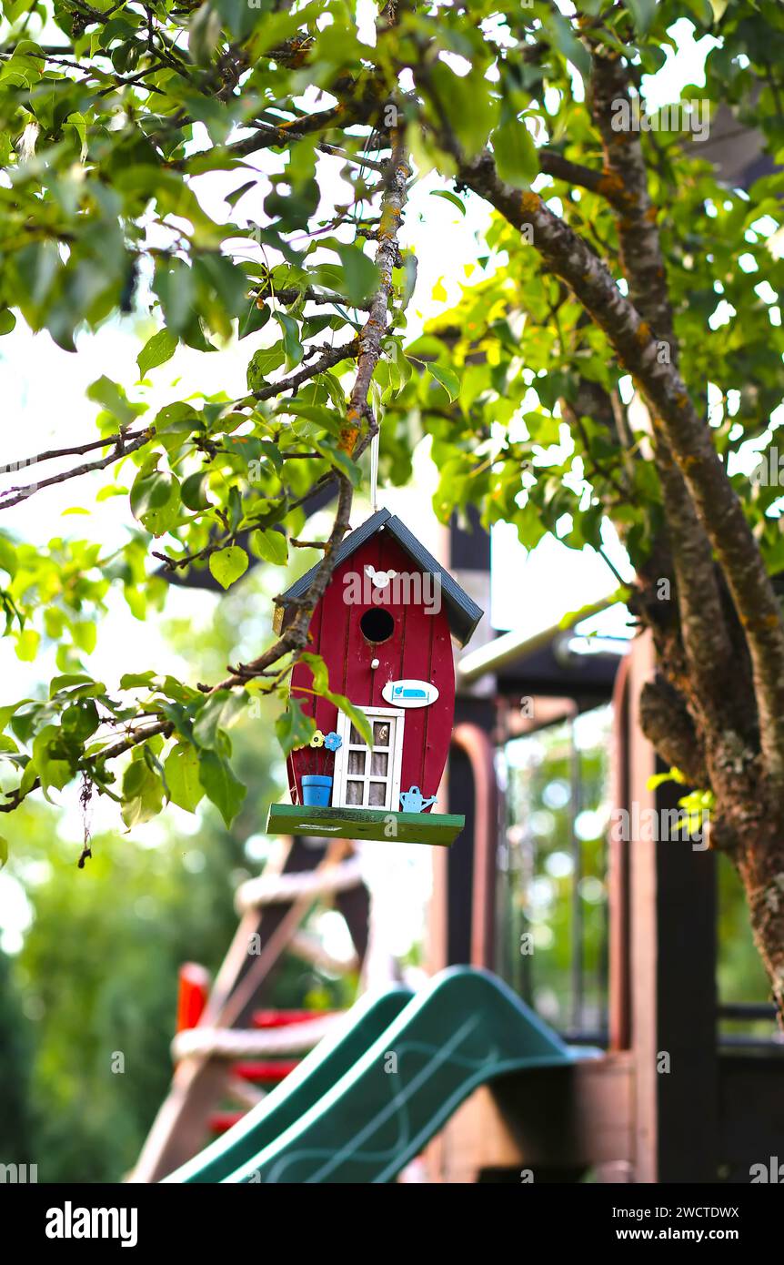 Wooden blue birdhouse on a apple tree in the garden. Simple ?ute ...