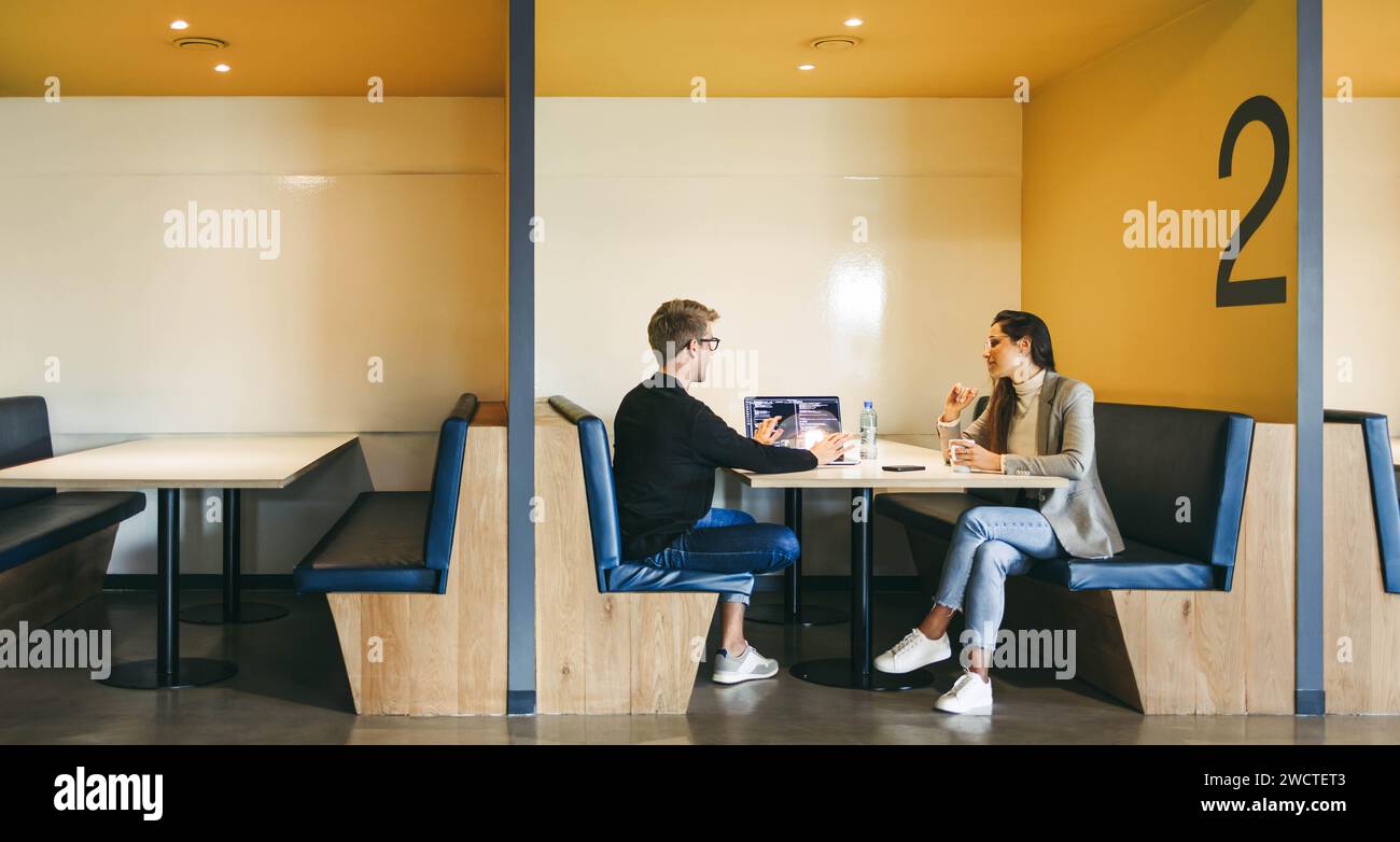Programmers working together in a diverse coworking space. Two coding ... Programmers working together in a diverse coworking space. Two coding ...