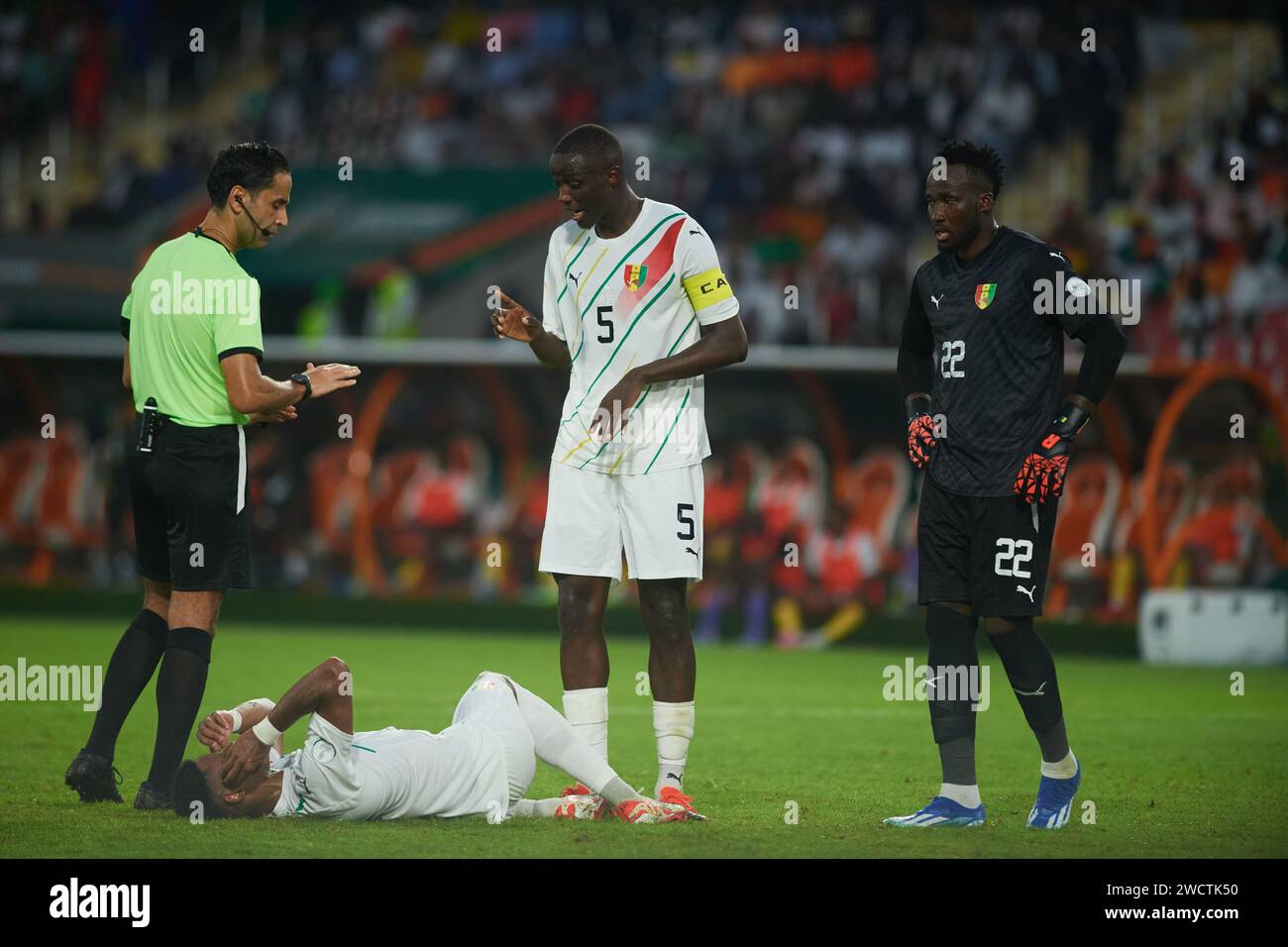 The referee Ibrahim Mutaz checking in on a Guinean player lying on the ...