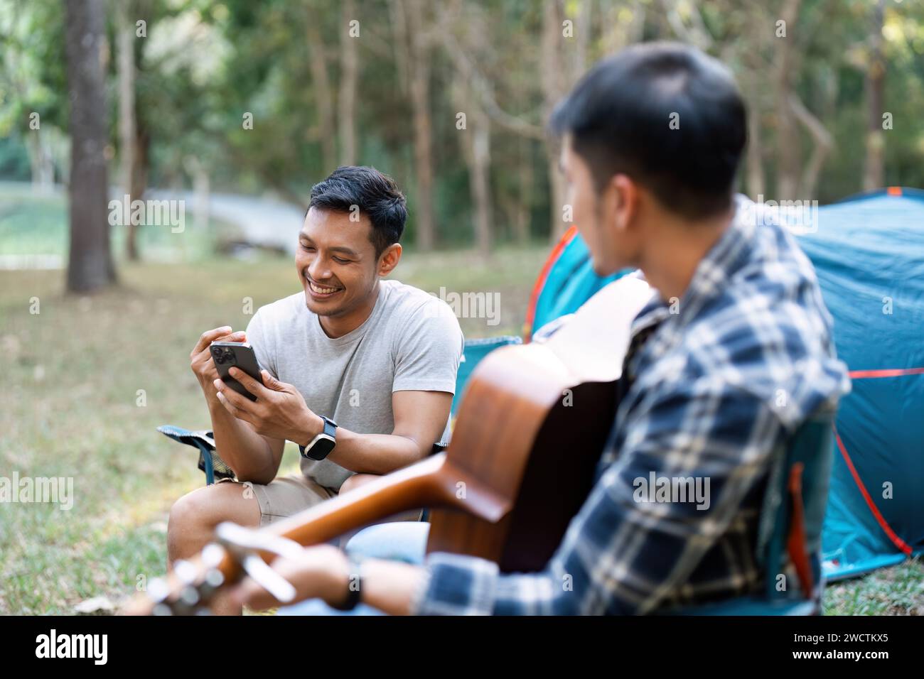 LGBTQIA Gay couple camping together in woods for holidays and relax on ...
