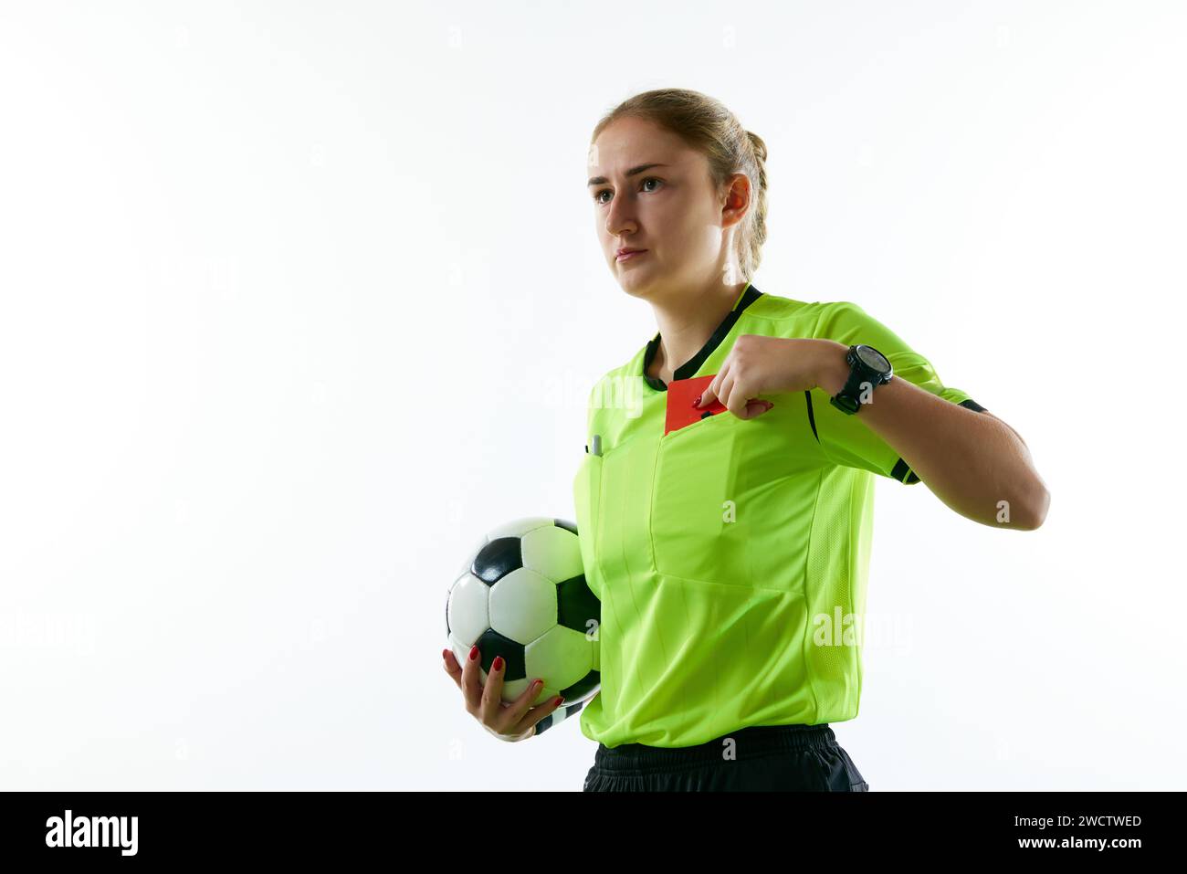 Young woman, female soccer referee holding ball, stopping game and ...