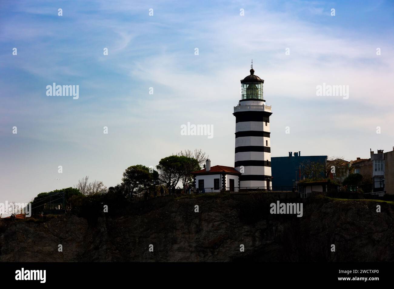 a lighthouse on the cliffs in a town at daytime Stock Photo - Alamy