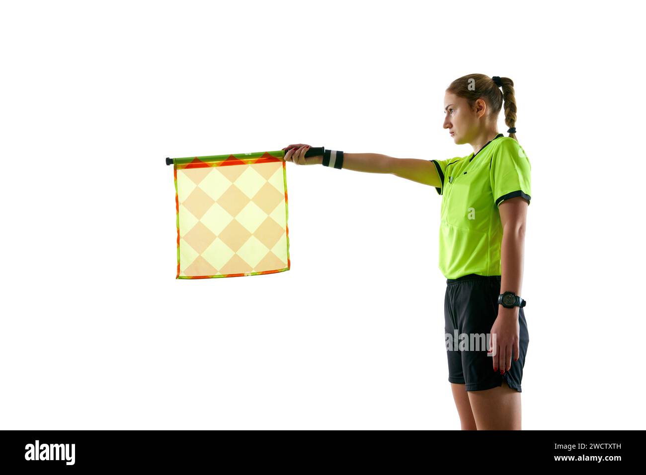 Assistant referee, young woman in uniform standing on field and raising ...
