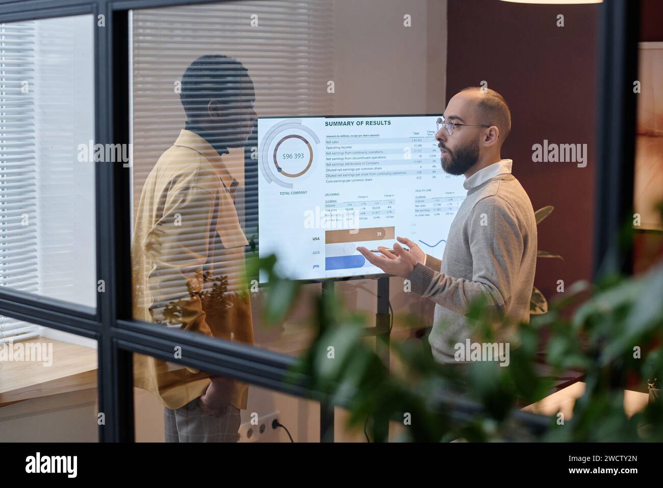 Office employee talking to his black colleague about infographics on ...