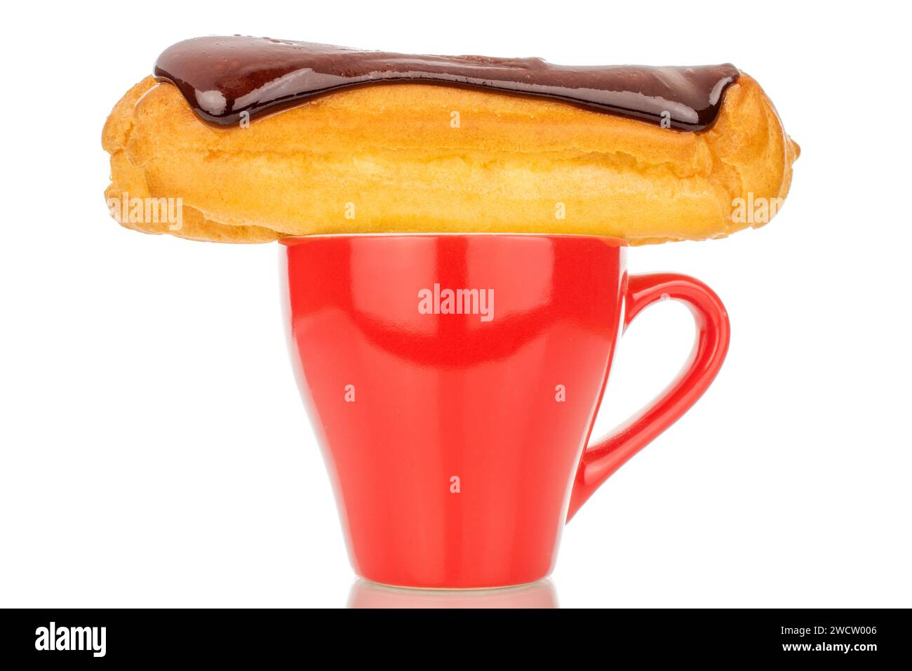 One delicious chocolate eclair with a red ceramic cup, close-up ...