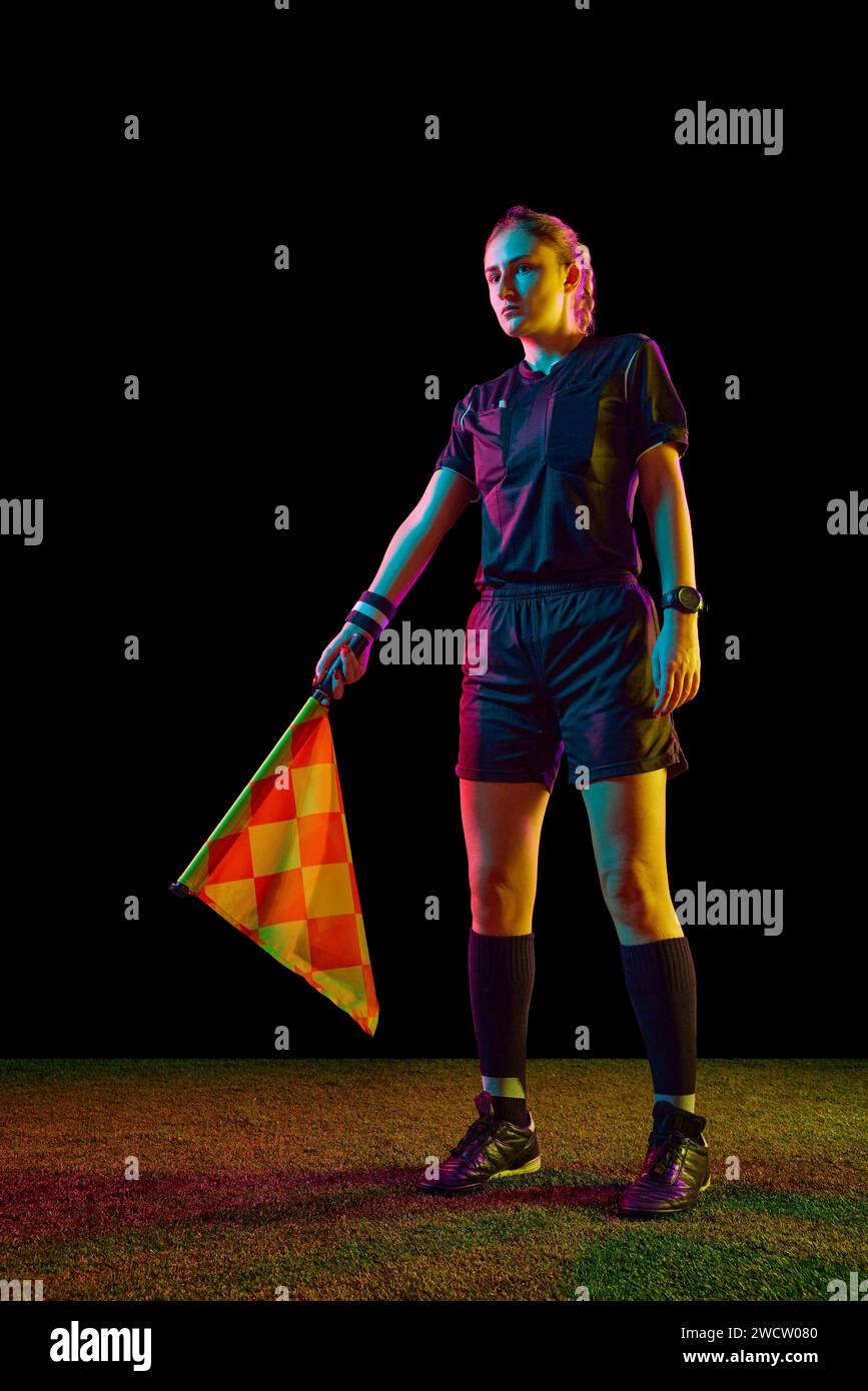 Young woman, female referee in uniform standing with flag, controlling ...