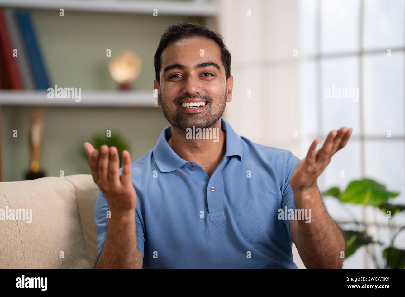 Happy indian man talking by looking camera on video call while sitting ...