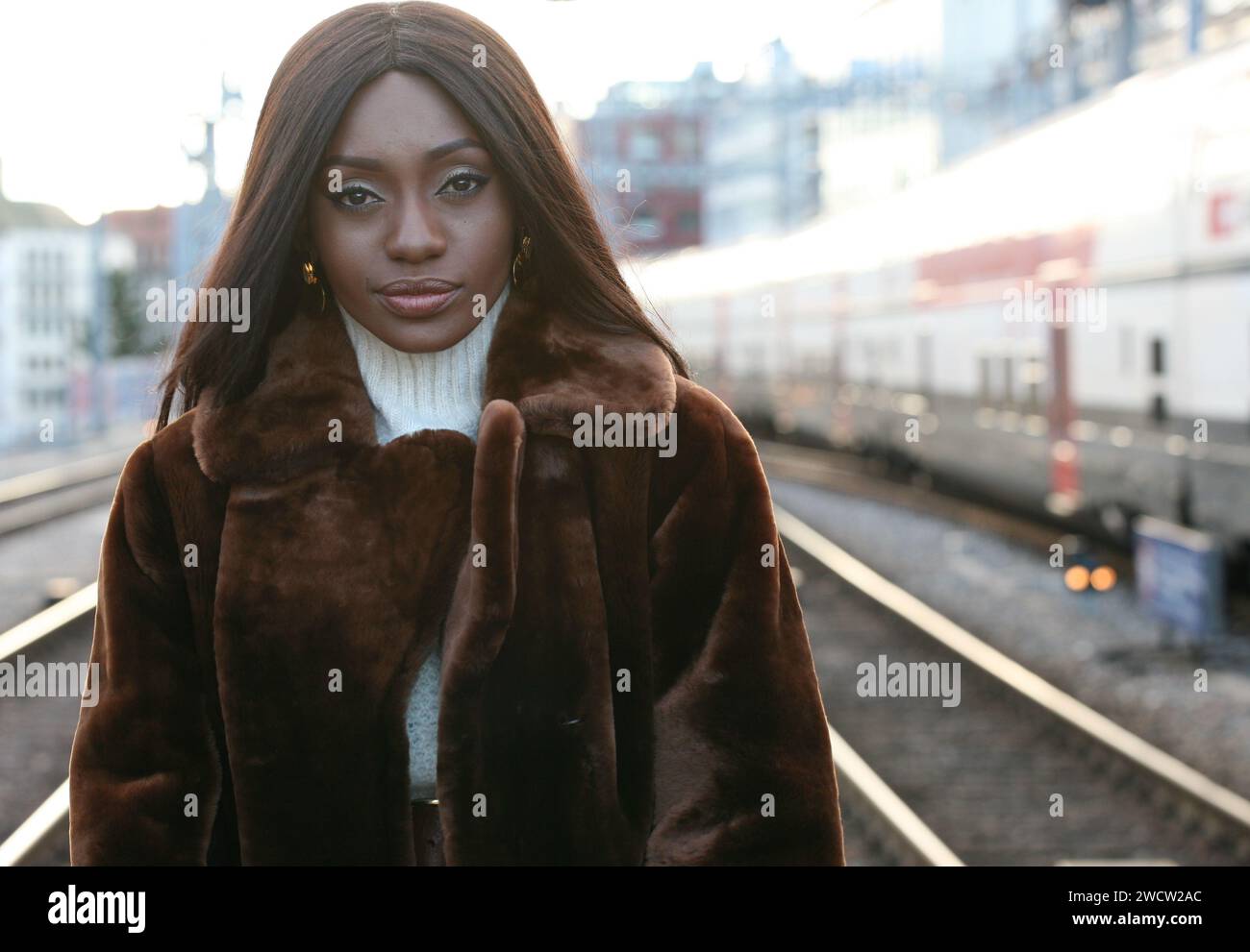 Beautiful black girl wrapped up in a fur coat as she walks along the ...