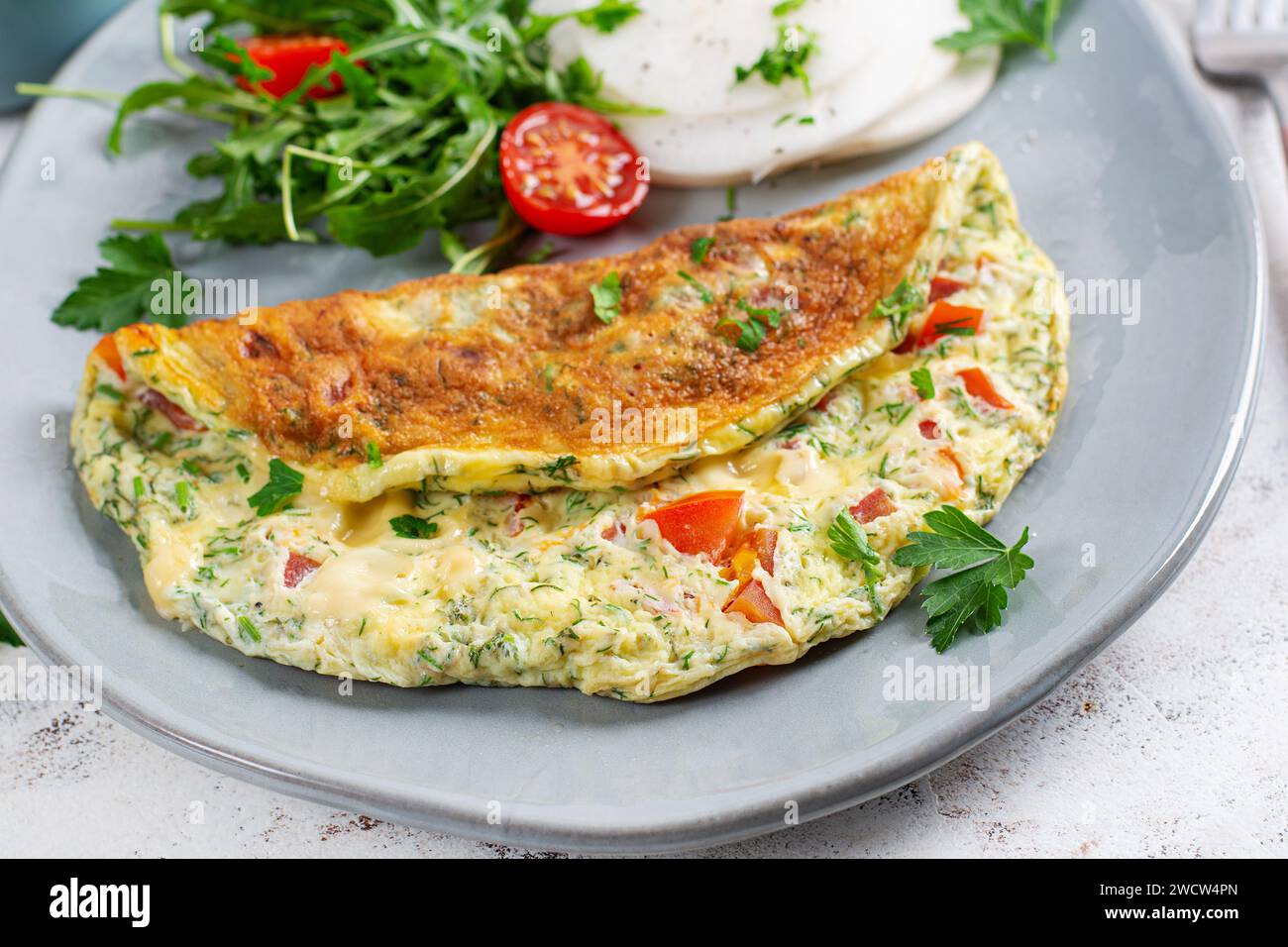Omelette with tomatoes and salad on plate. Frittata - italian omelet ...