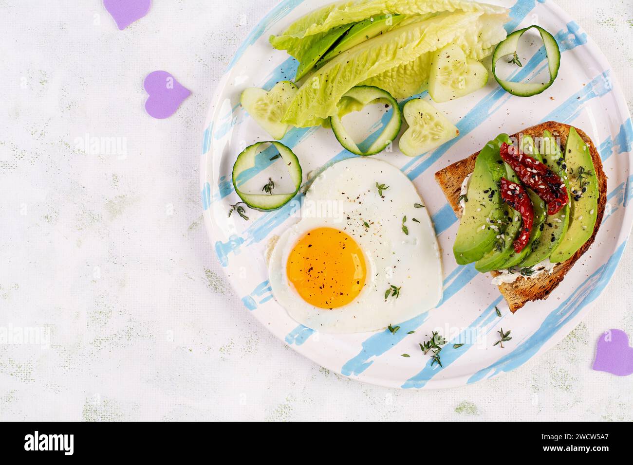 Romantic breakfast for Valentine's Day. Fried egg and toast with avocado and cream cheese. Top ...
