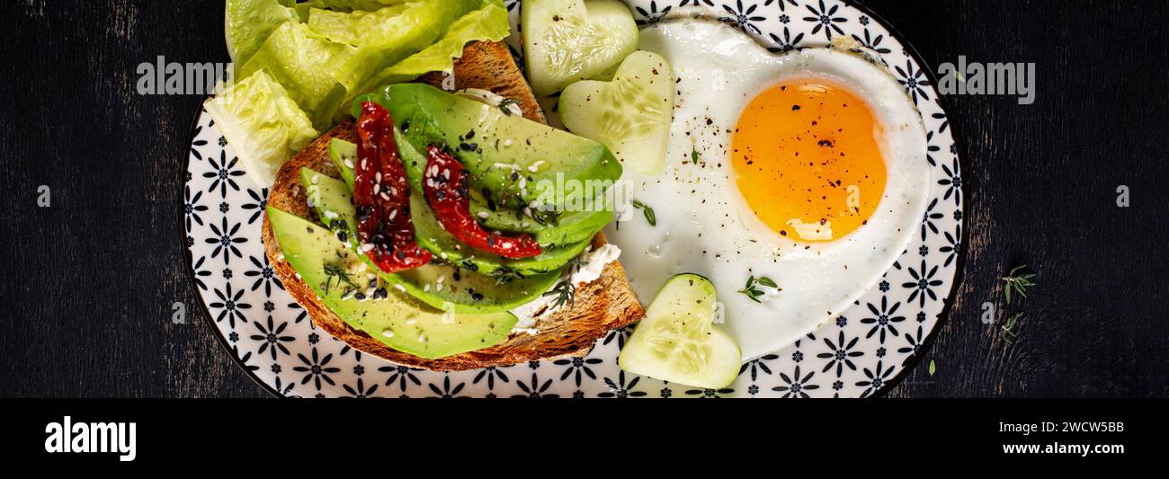 Romantic breakfast for Valentine's Day. Fried egg and toast with avocado and cream cheese. Top ...
