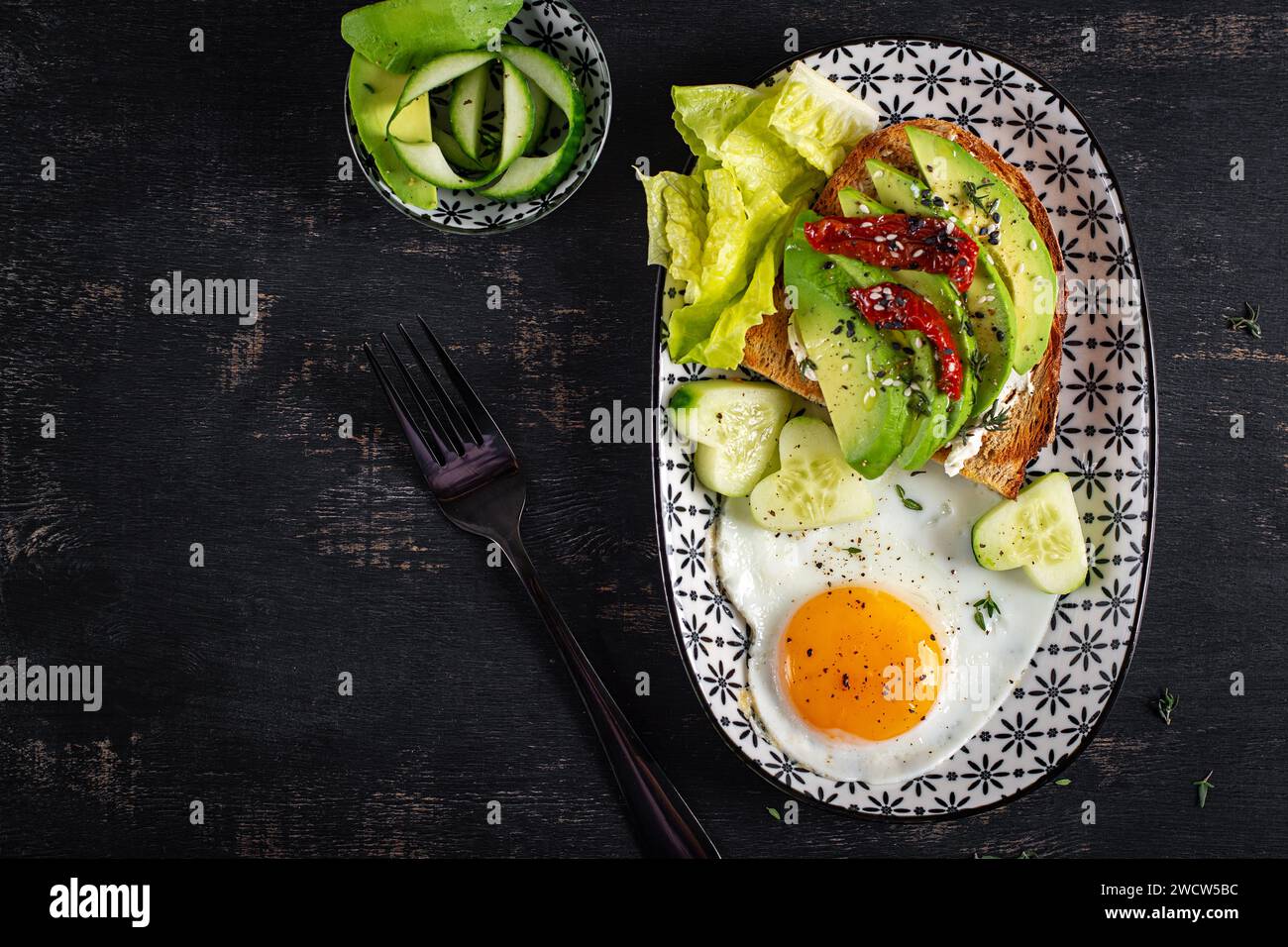 Romantic breakfast for Valentine's Day. Fried egg and toast with avocado and cream cheese. Top ...