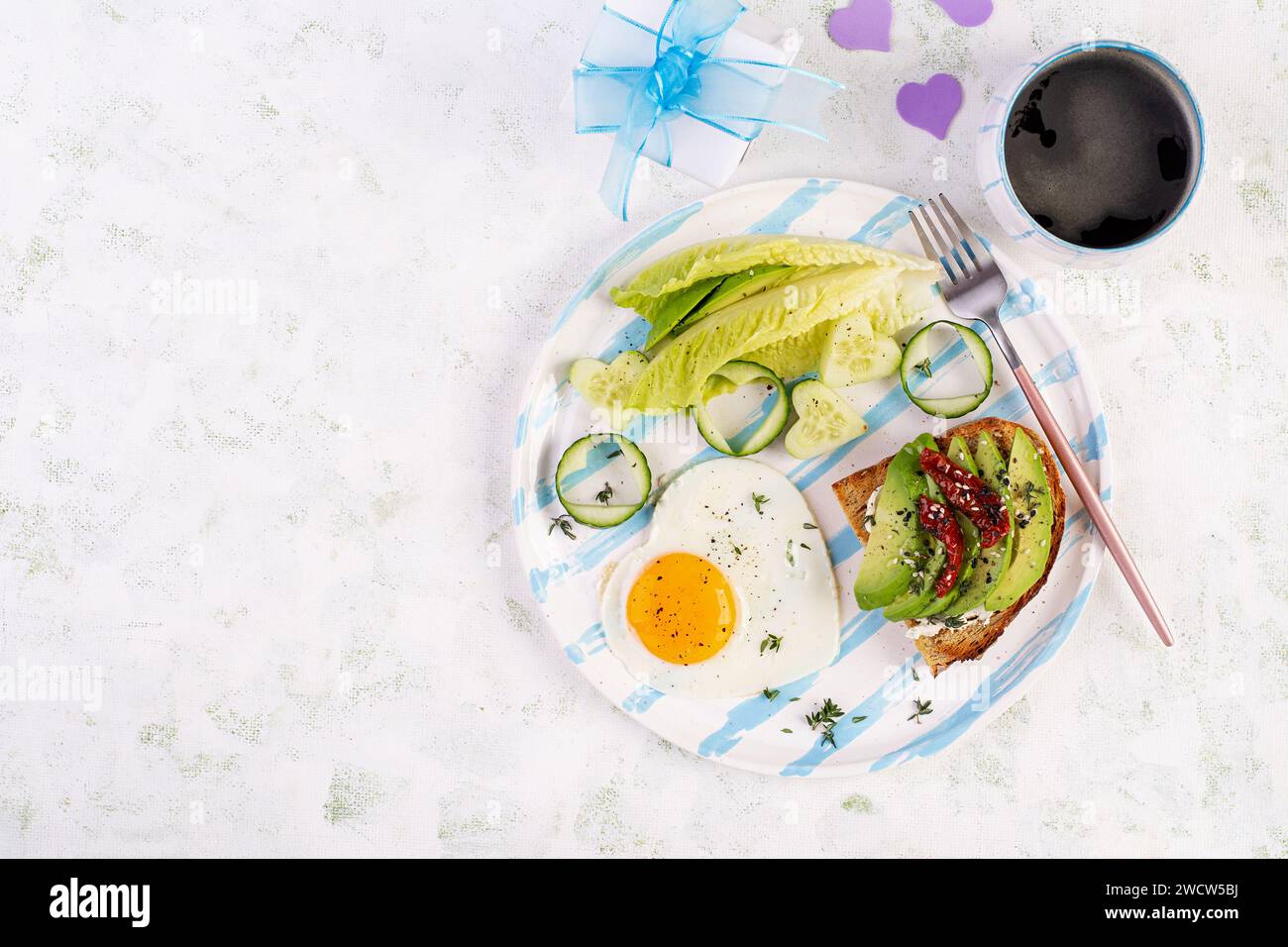 Romantic breakfast for Valentine's Day. Fried egg and toast with avocado and cream cheese. Top ...