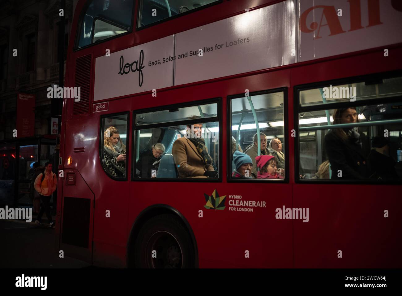 Bus commuters travel home on a winters night in London's West End area ...