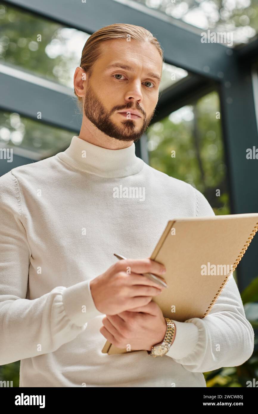 focused handsome architect in white comfy turtleneck with beard holding ...