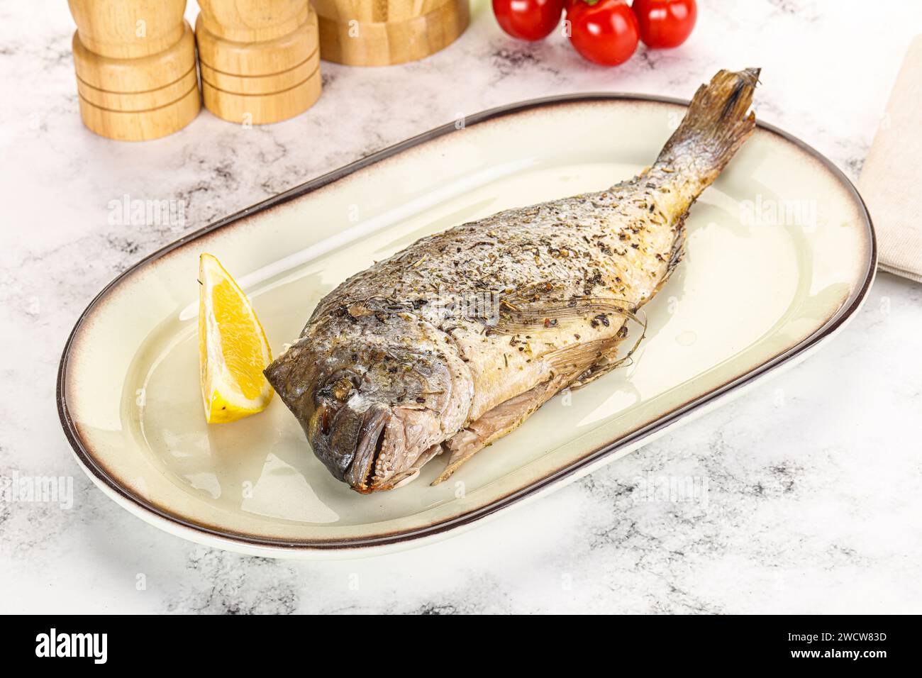 Baked Dorado fish served lemon slice Stock Photo - Alamy