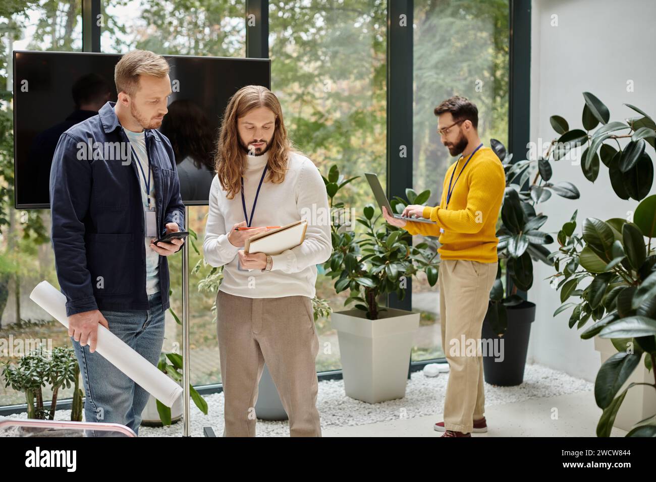 focused attractive coworkers in casual attires working together on ...