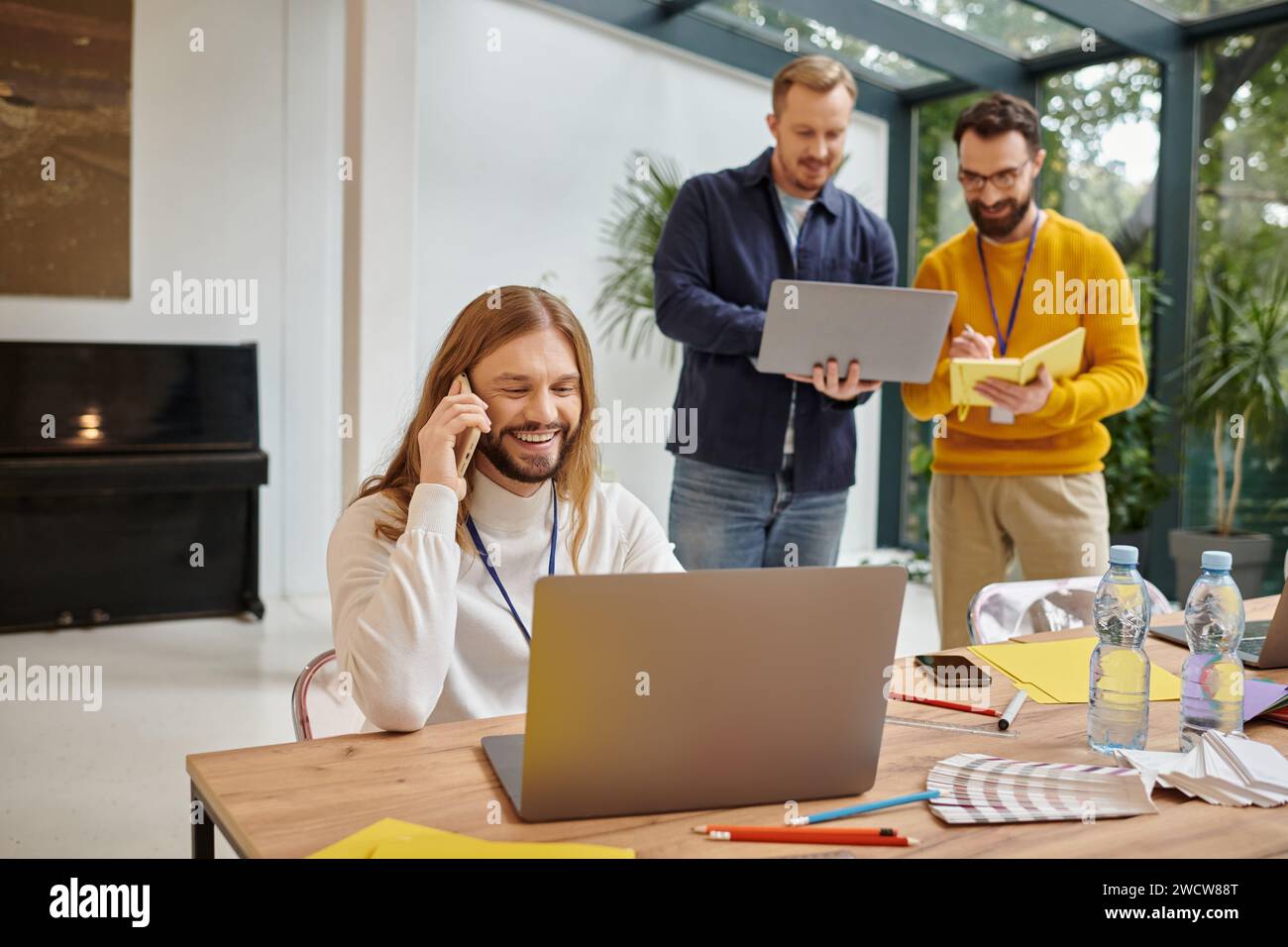 happy attractive businessmen in casual outfit working attentively on ...