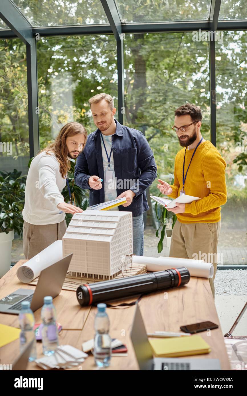 joyful handsome architects in casual outfits working together on their ...
