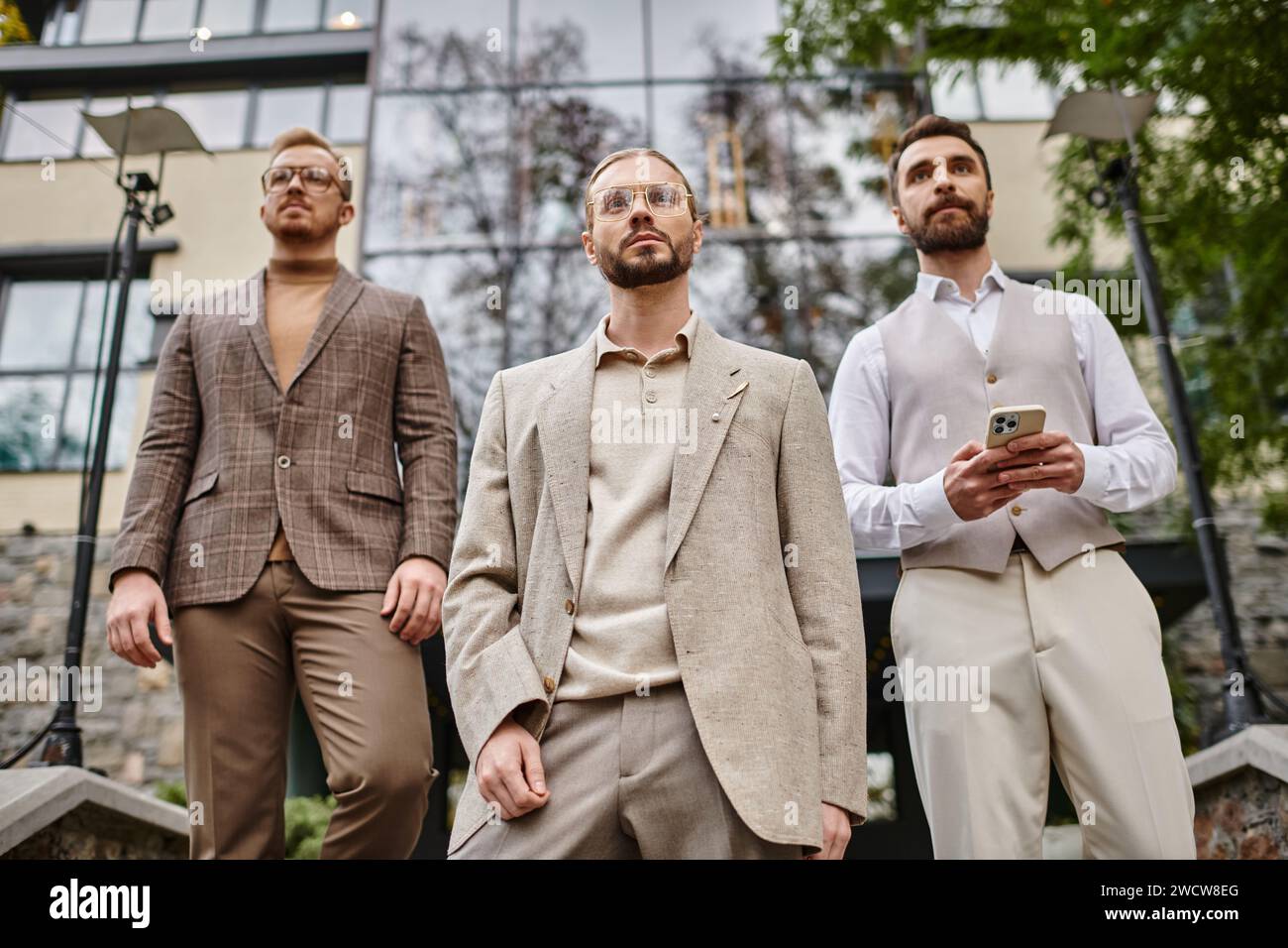 concentrated handsome business leaders in elegant attires posing ...