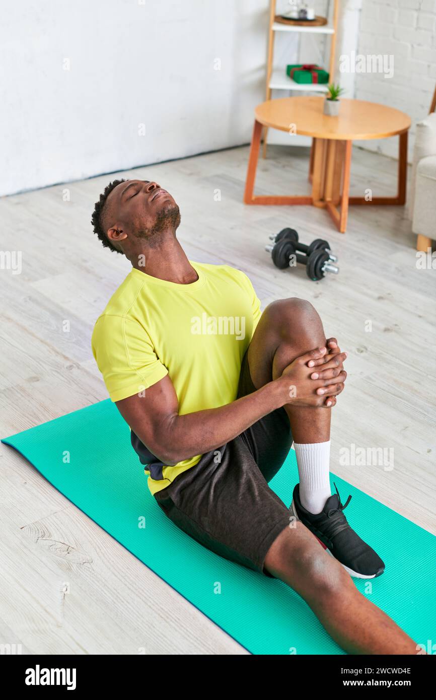 athletic african american guy sitting and stretching on fitness man in ...