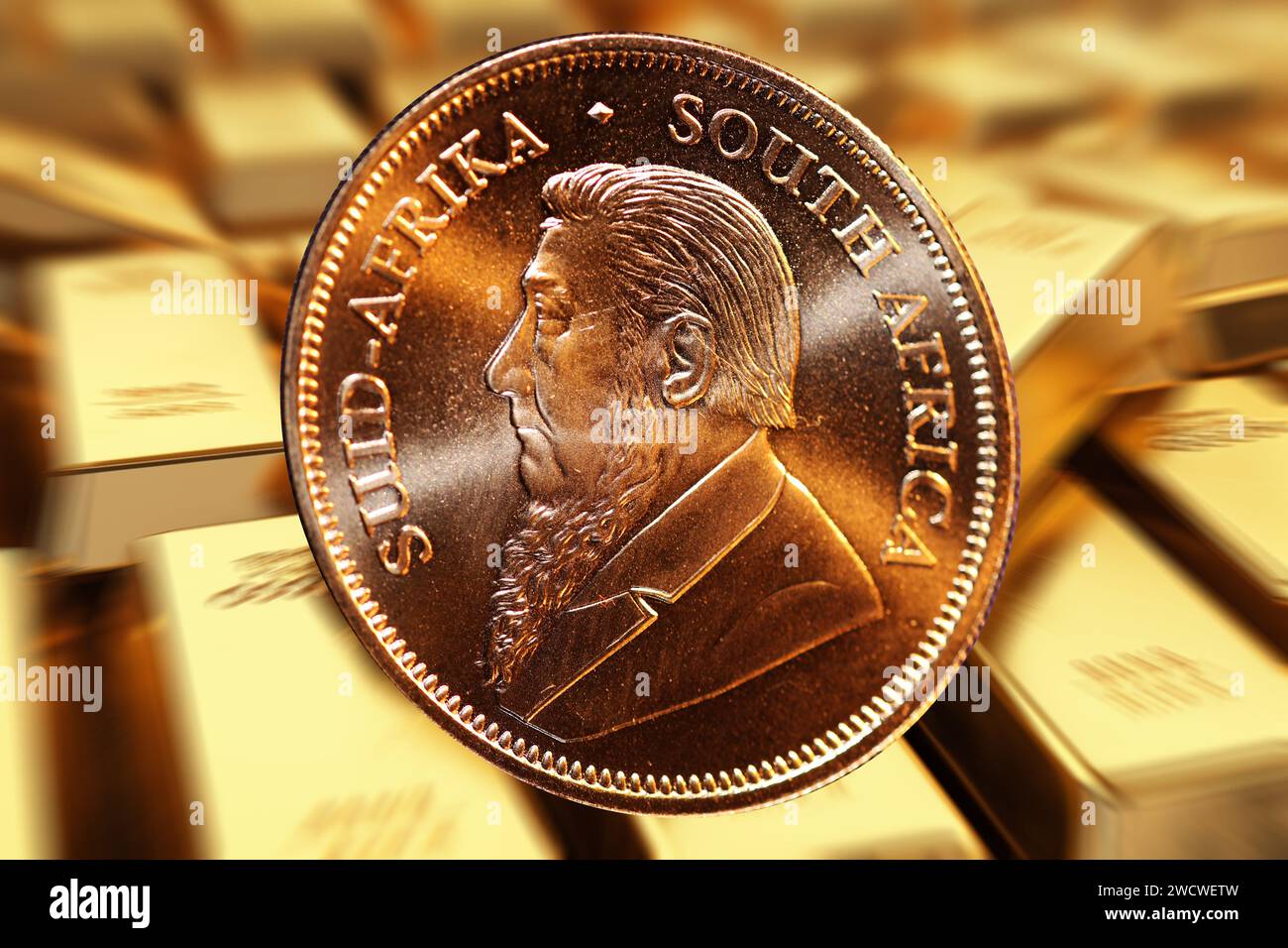 Close-up of a Krugerrand gold coin, in the background blurred gold bars ...