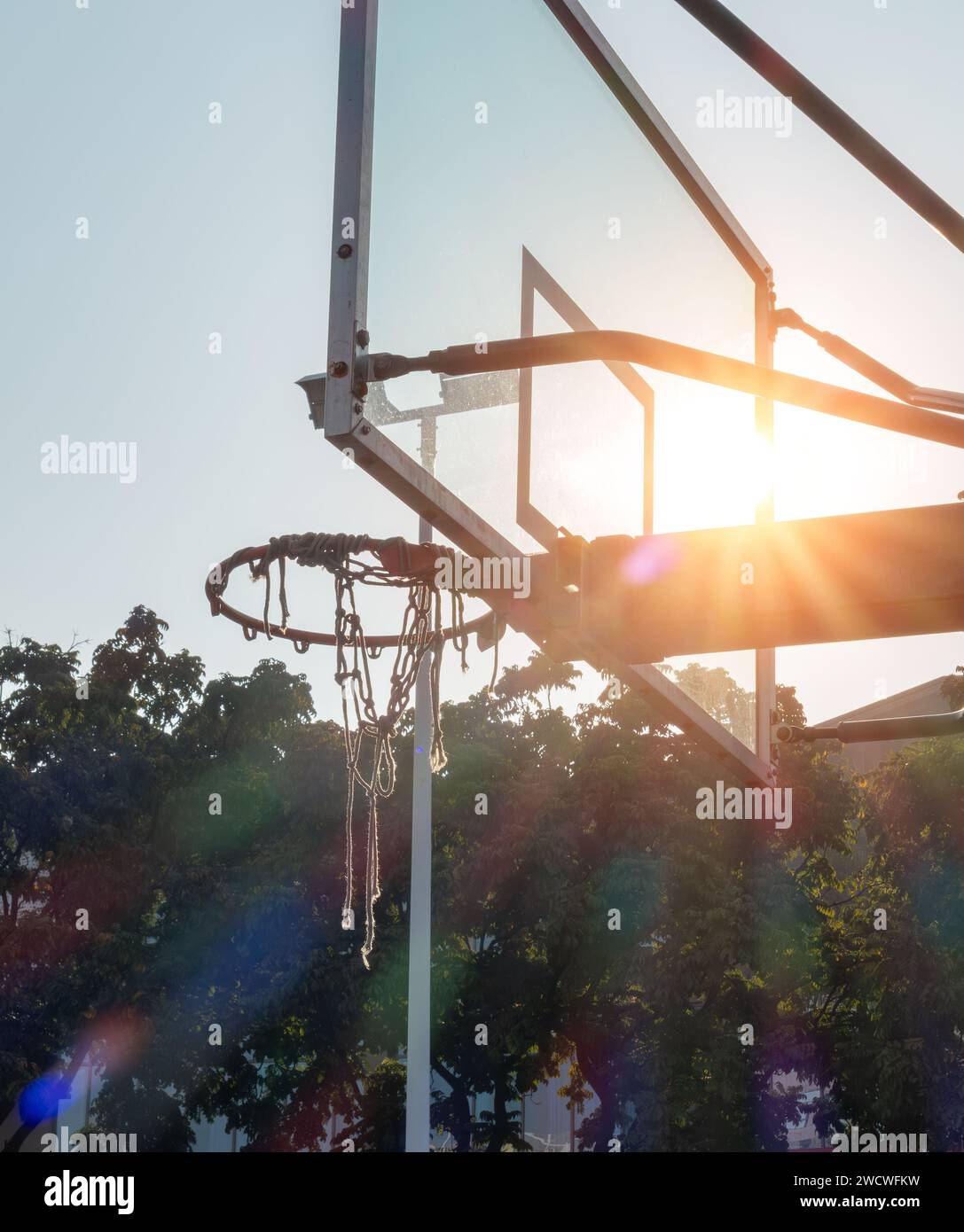 basketball hoop and board against the sun with beautiful sun flare in ...