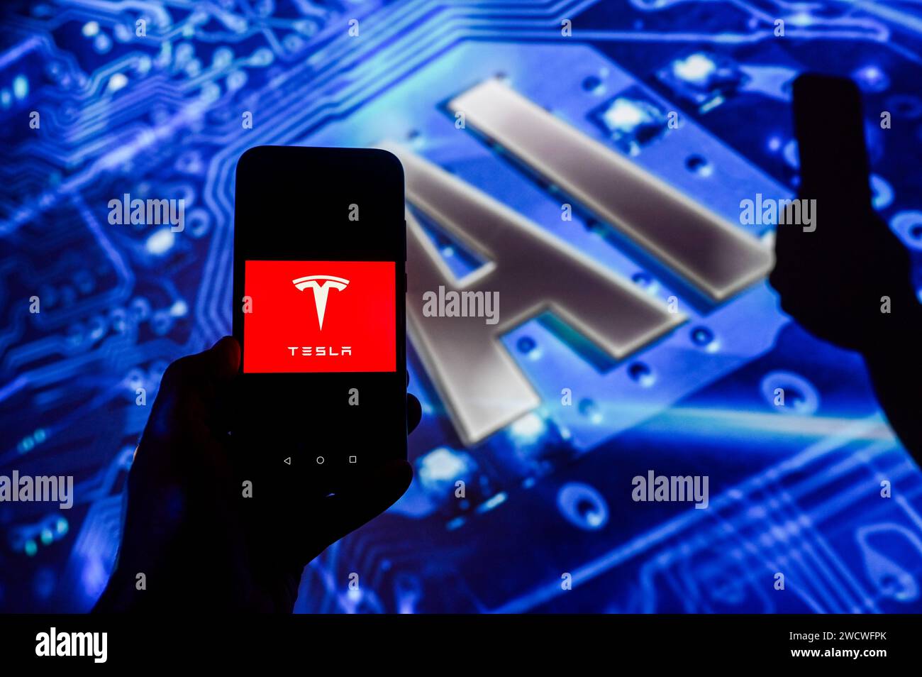 In this photo illustration, a Tesla logo is displayed on a smartphone ...