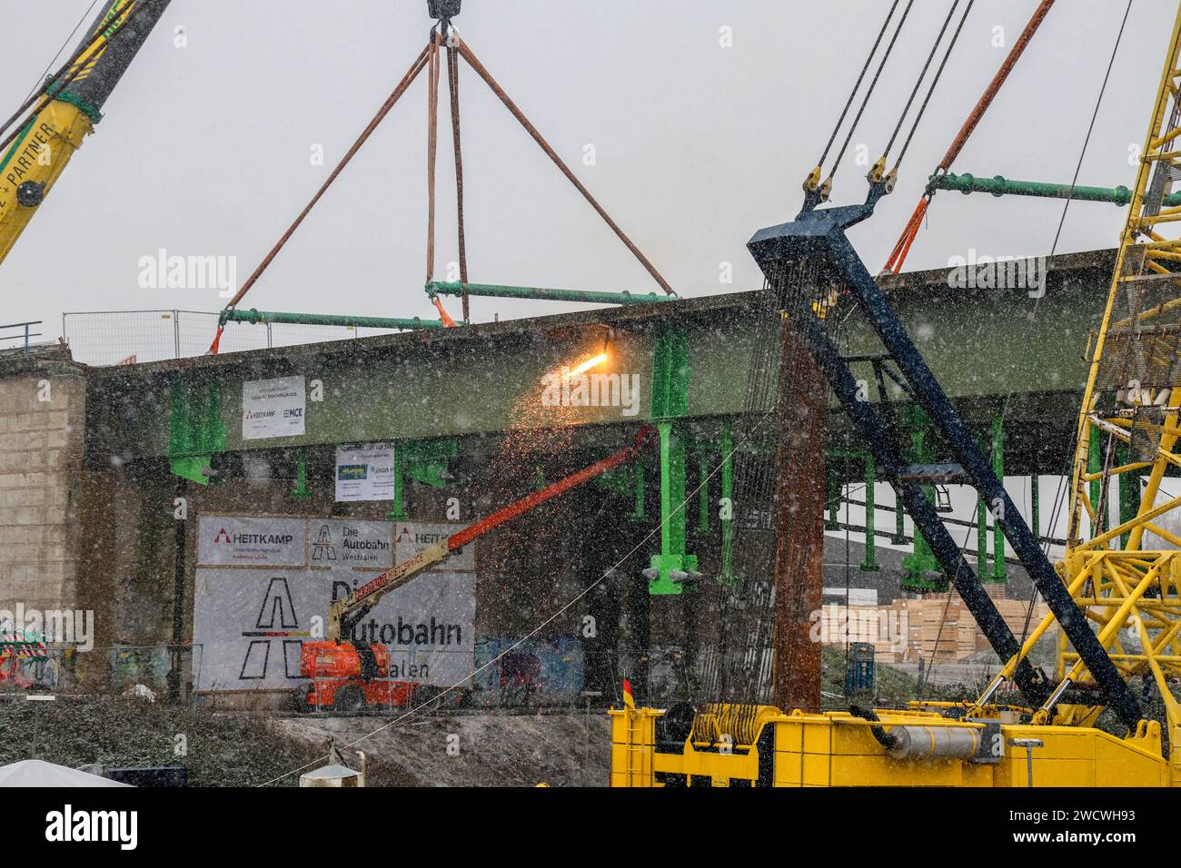 Zwei große Spezialkräne heben die 320 Tonnen schwere Brücke aus ihrer ...