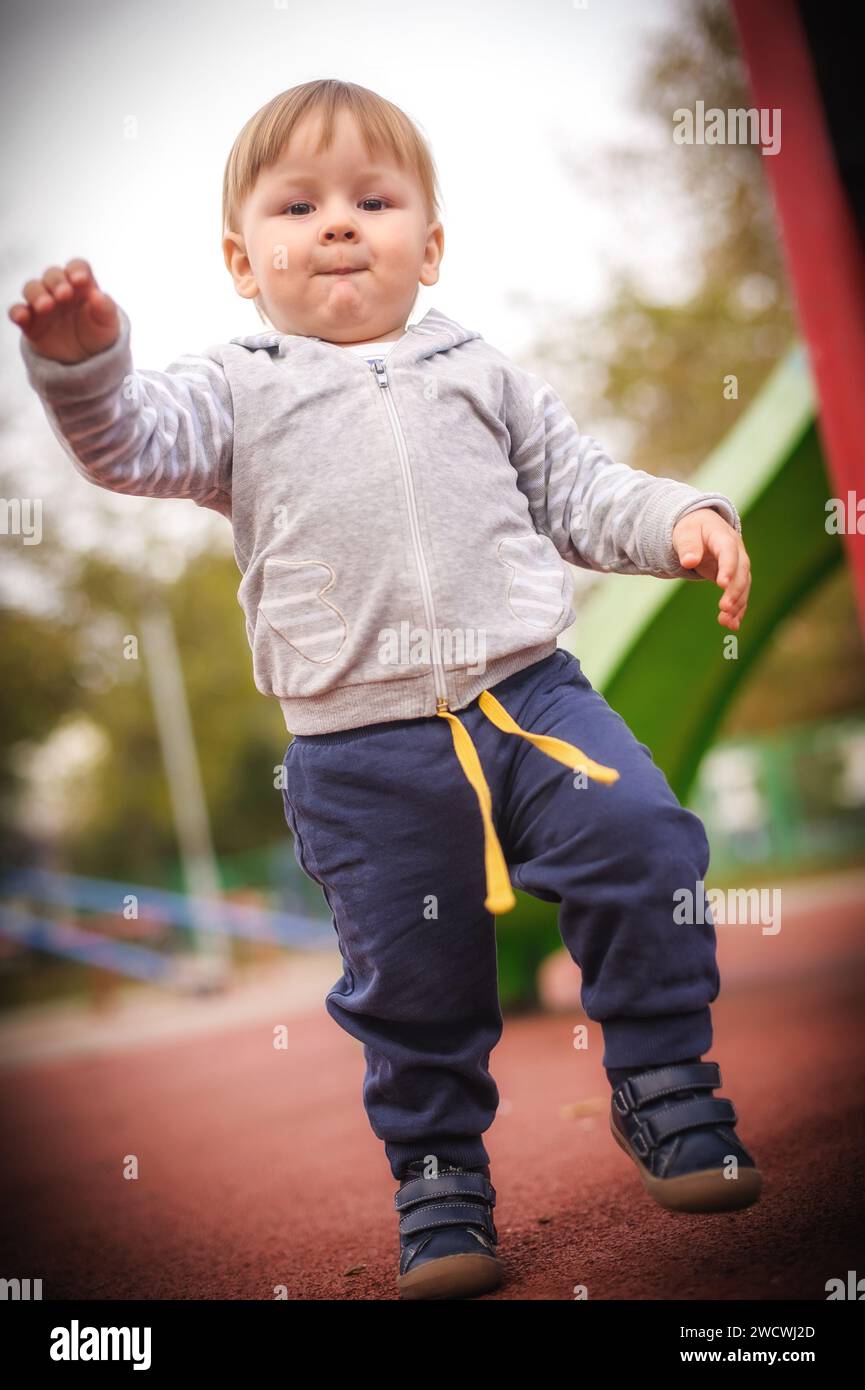 Lively, happy and smiling boy happily runs around the children's ...