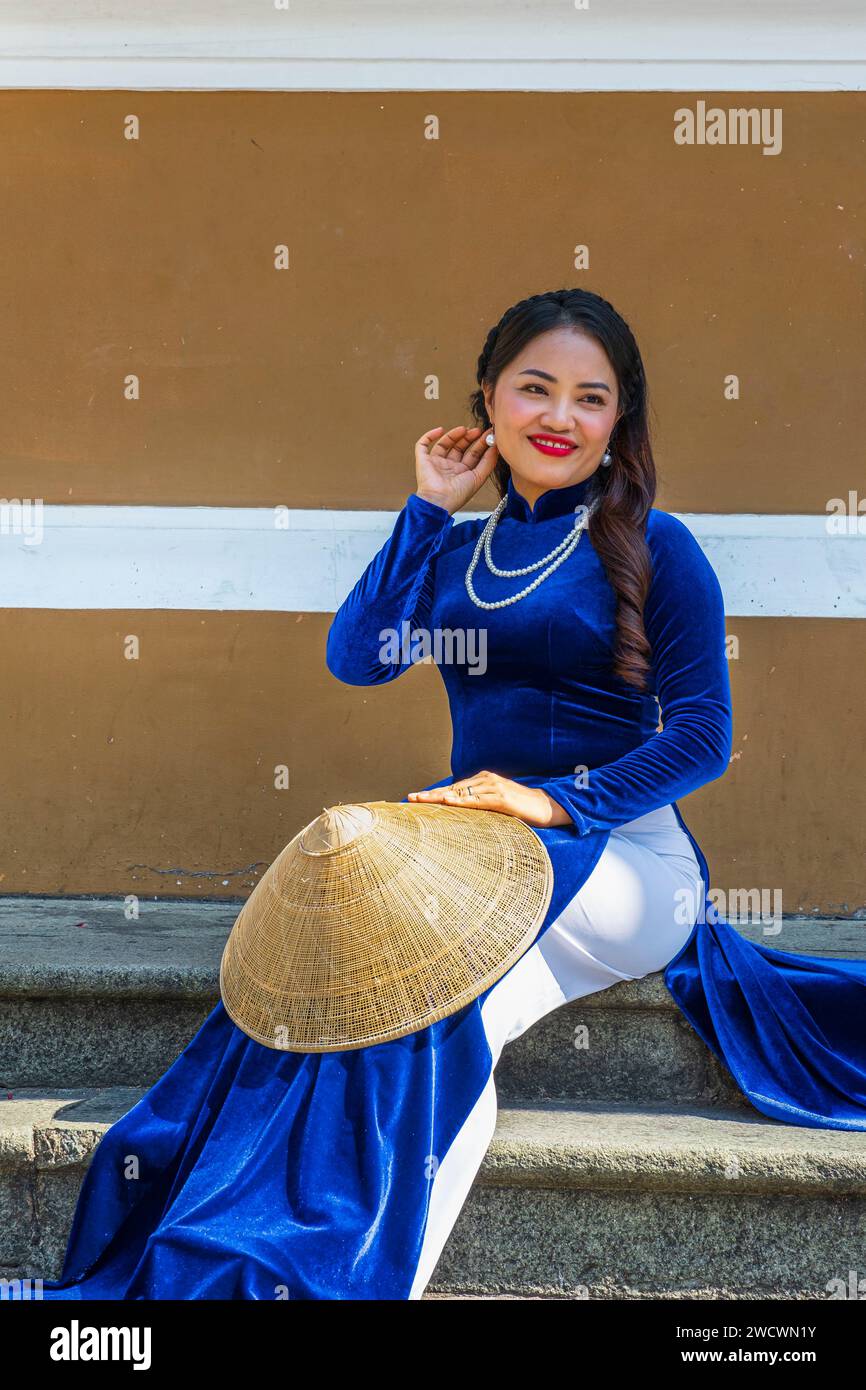 Vietnam, Ho Chi Minh City (Saigon), young woman wearing the áo dài, traditional Vietnamese dress ...