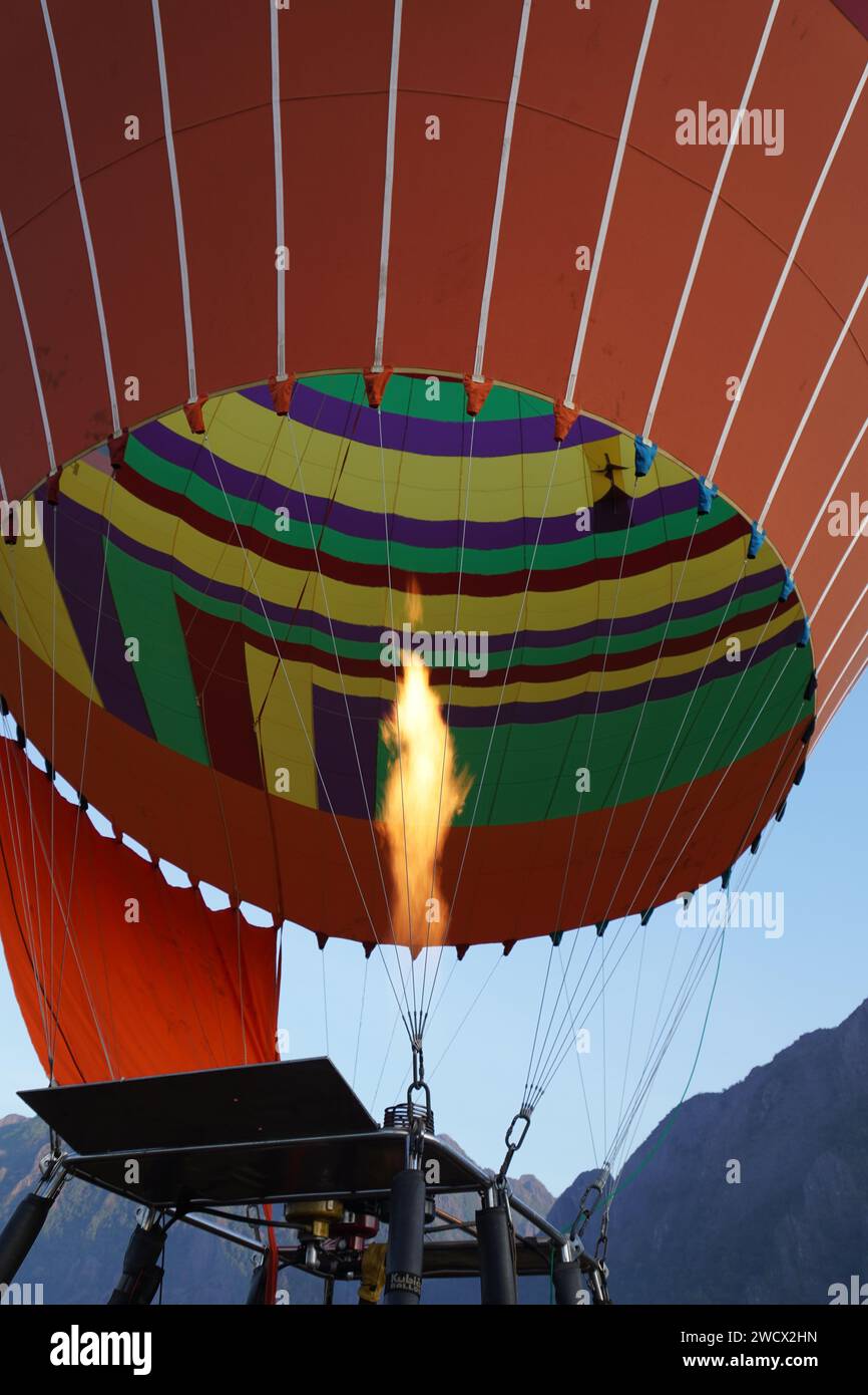 open flame of a colourful hot air balloon up in the sky in Vang Vieng ...